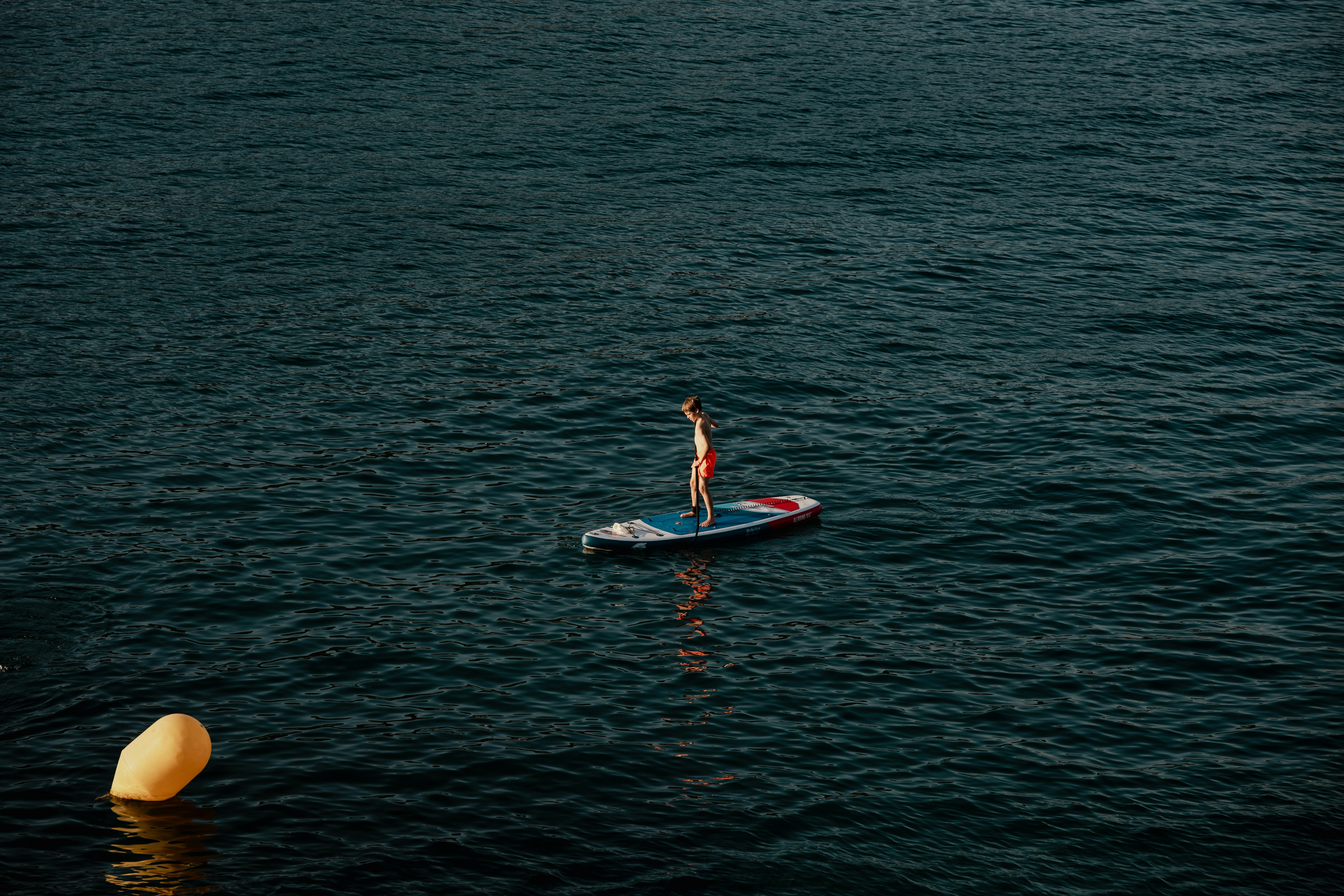 Solitary Stand: A Paddleboarder Amid Quiet Waves