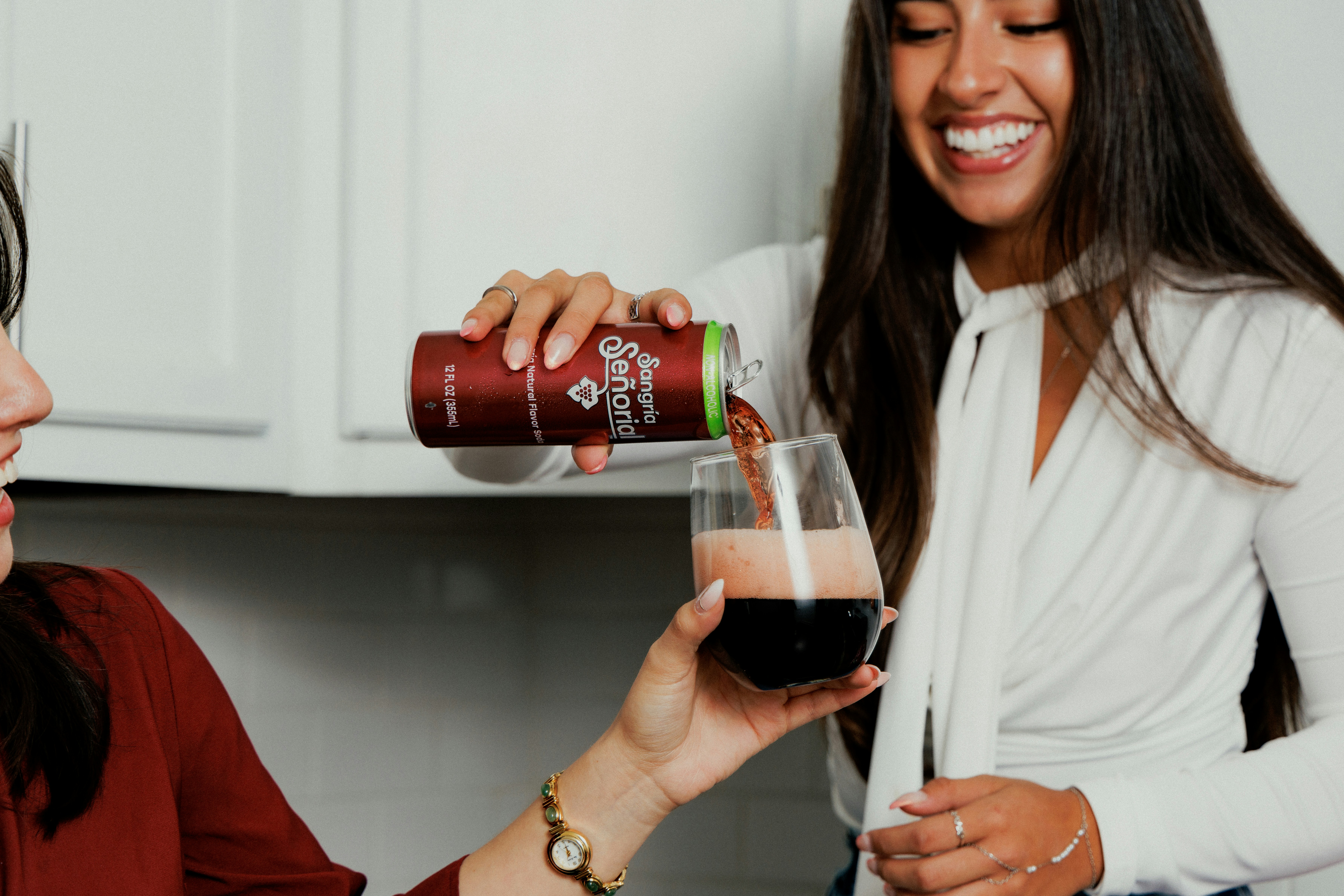 Wine poured, smiles shared: a candid moment in a kitchen