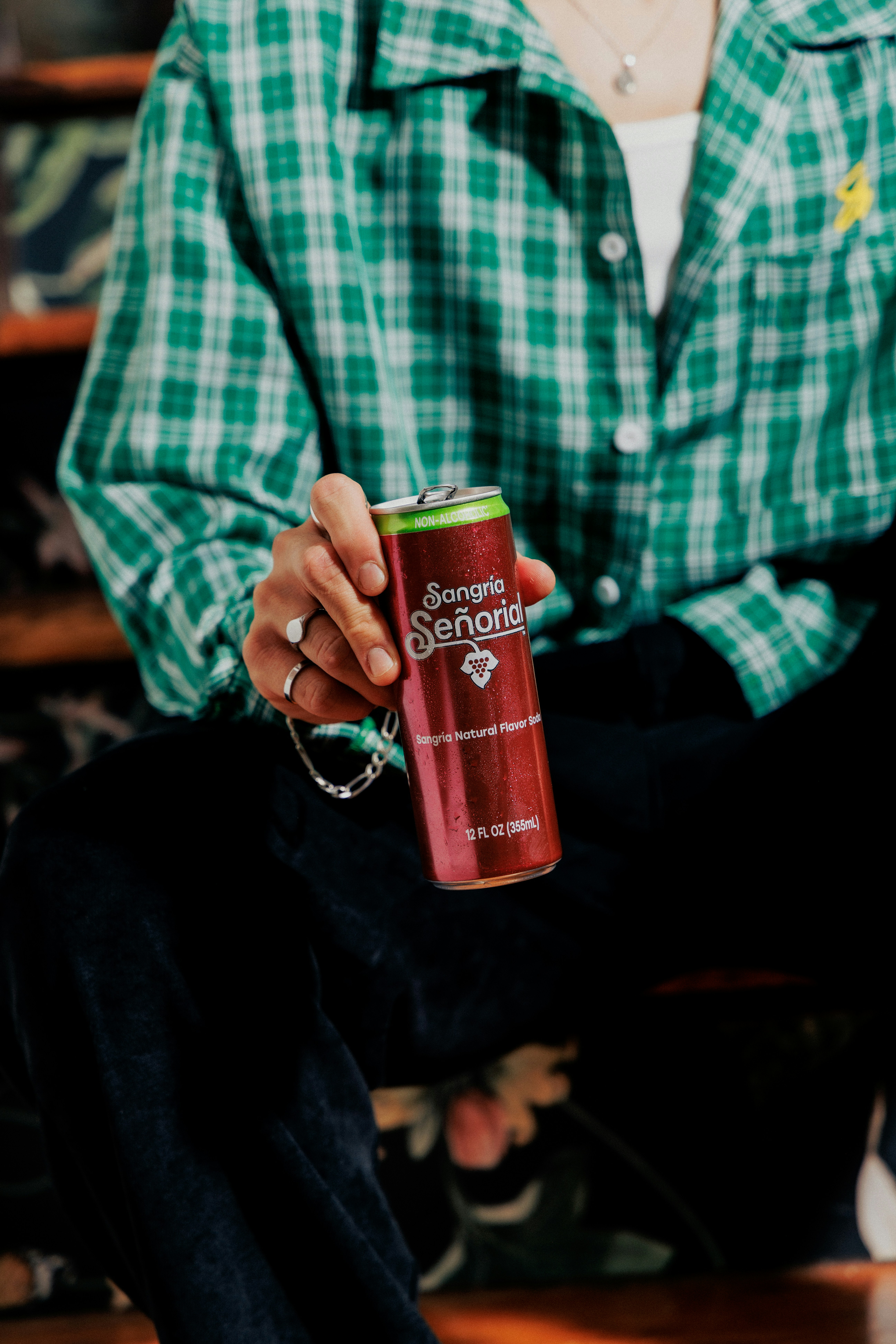 Green-checked Confidence: A Hand Extended with Sangria in Focus