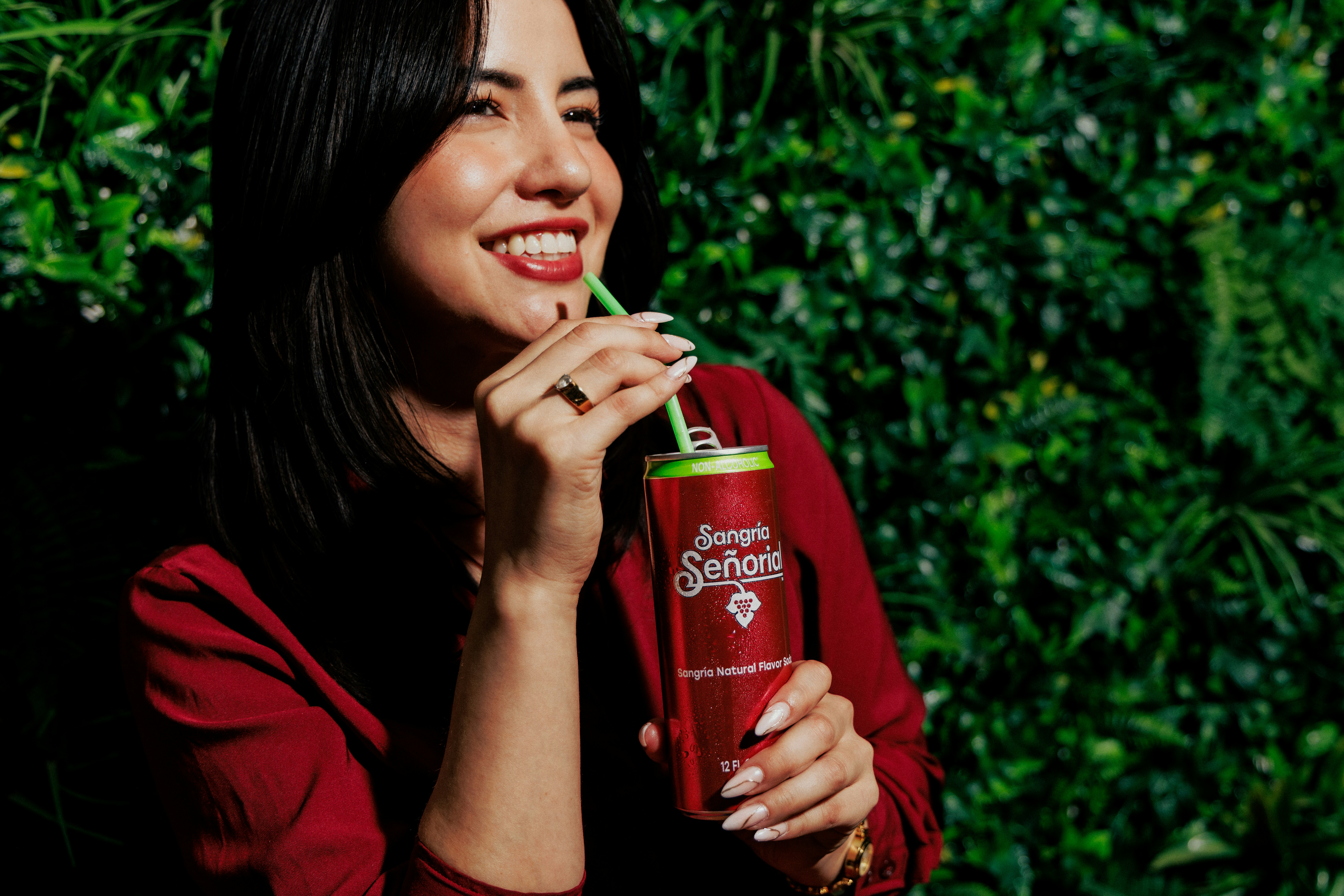 Sip of Confidence: A Woman Enjoying a Red Can Outdoors