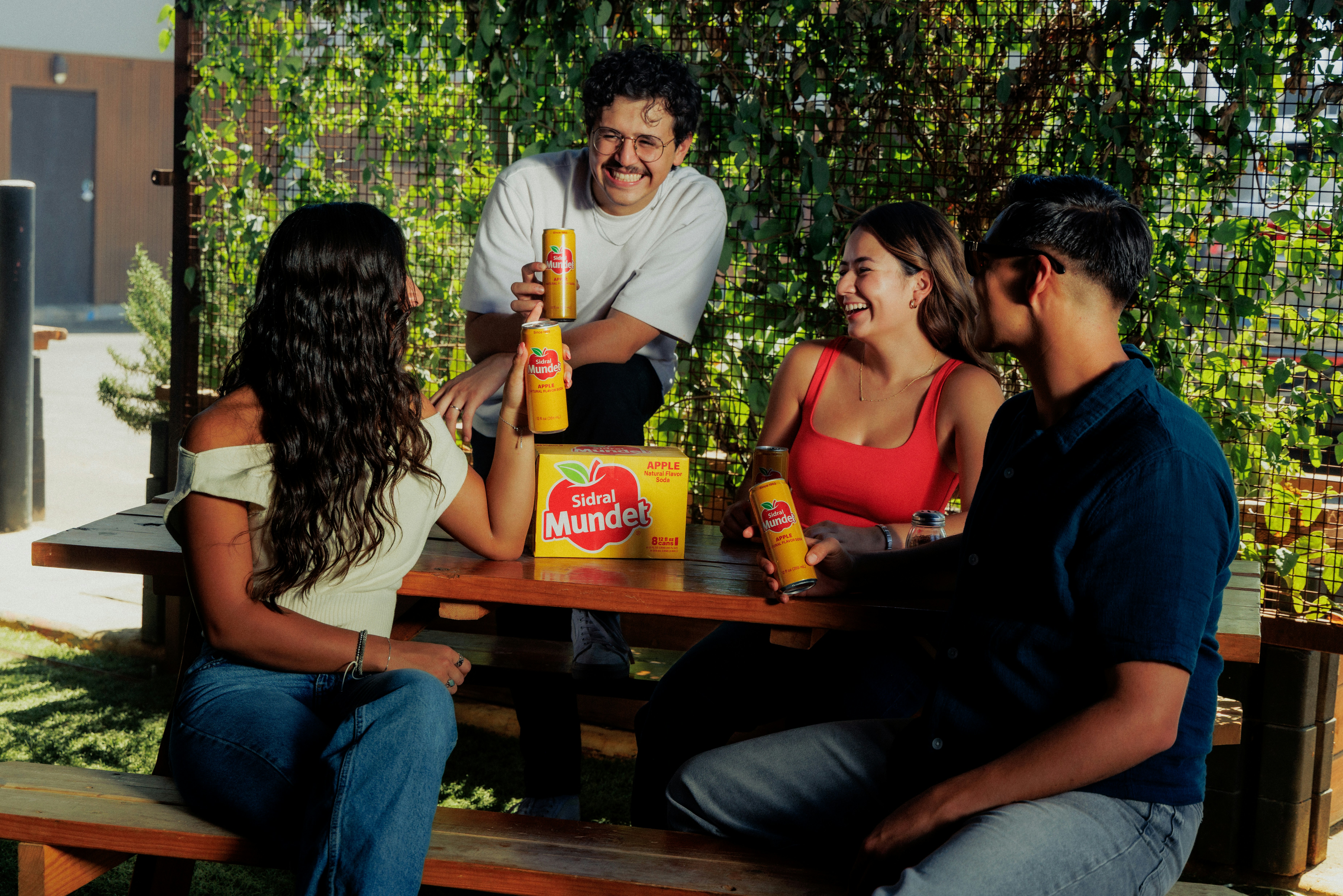 Joyful Gathering: Friends Share a Laugh Over a Bottle of Mundet