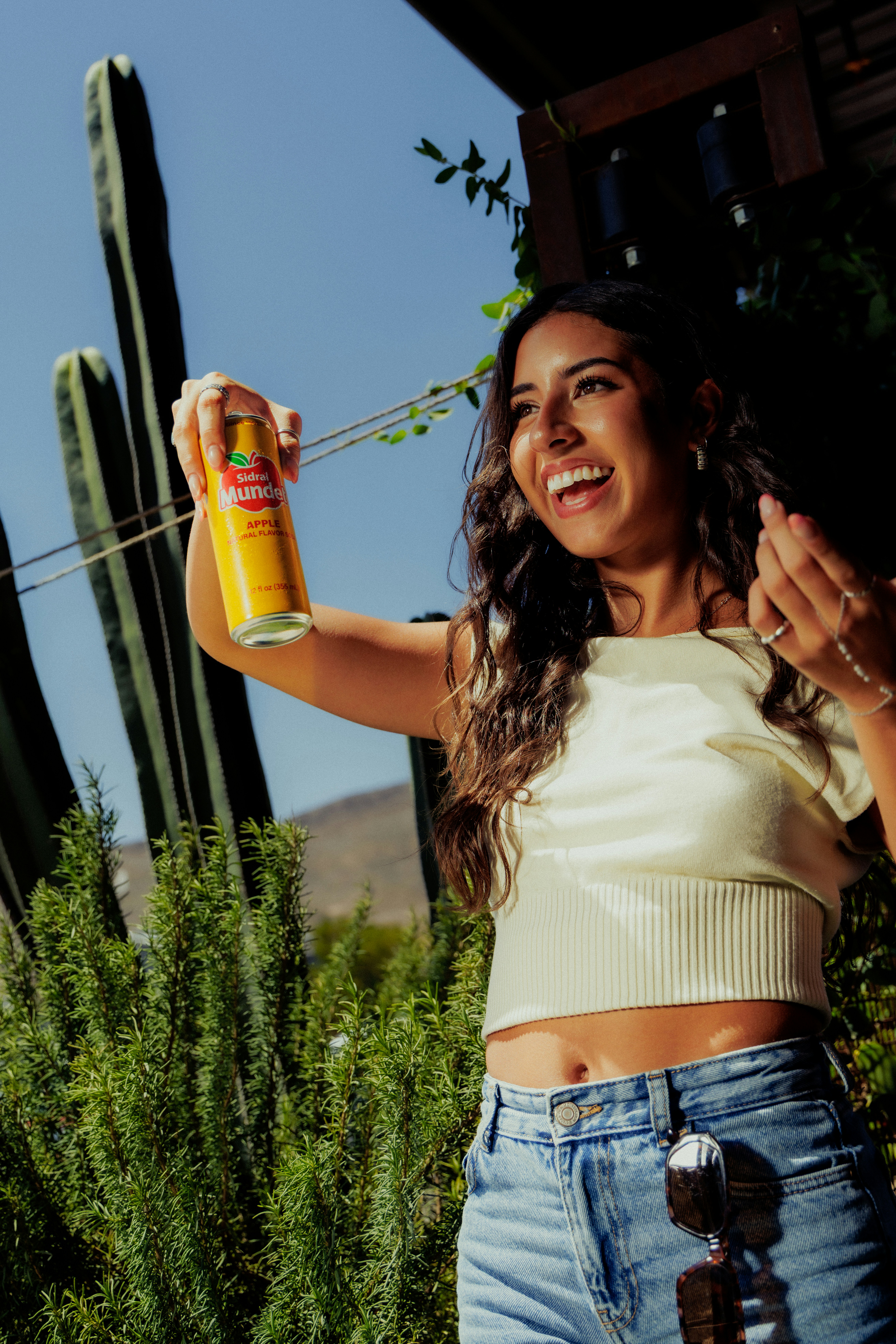 Joyful toast in sunlit garden with citrus-hued can in hand