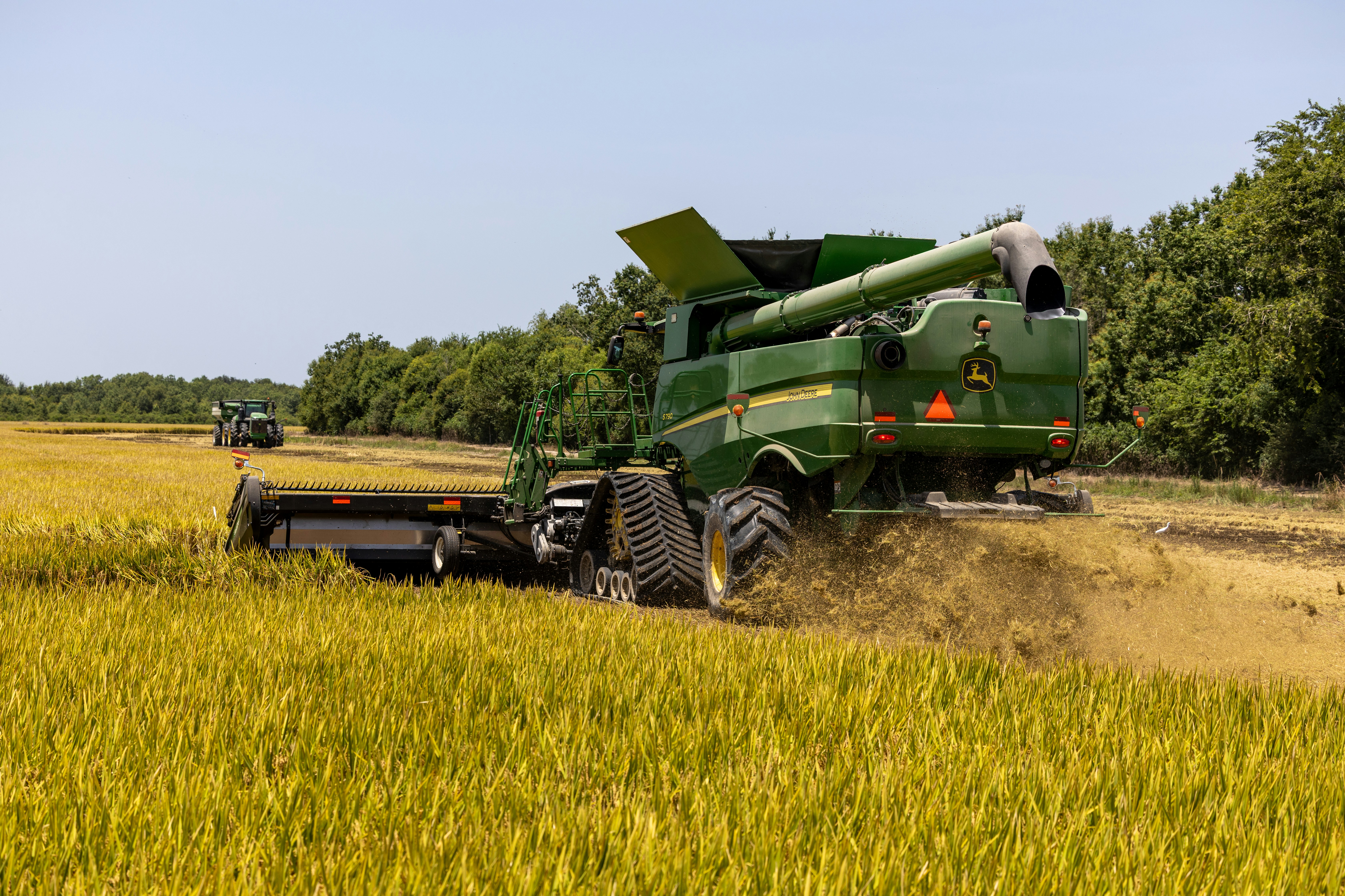 Harvesters in a Dusty Chase Across Golden Fields