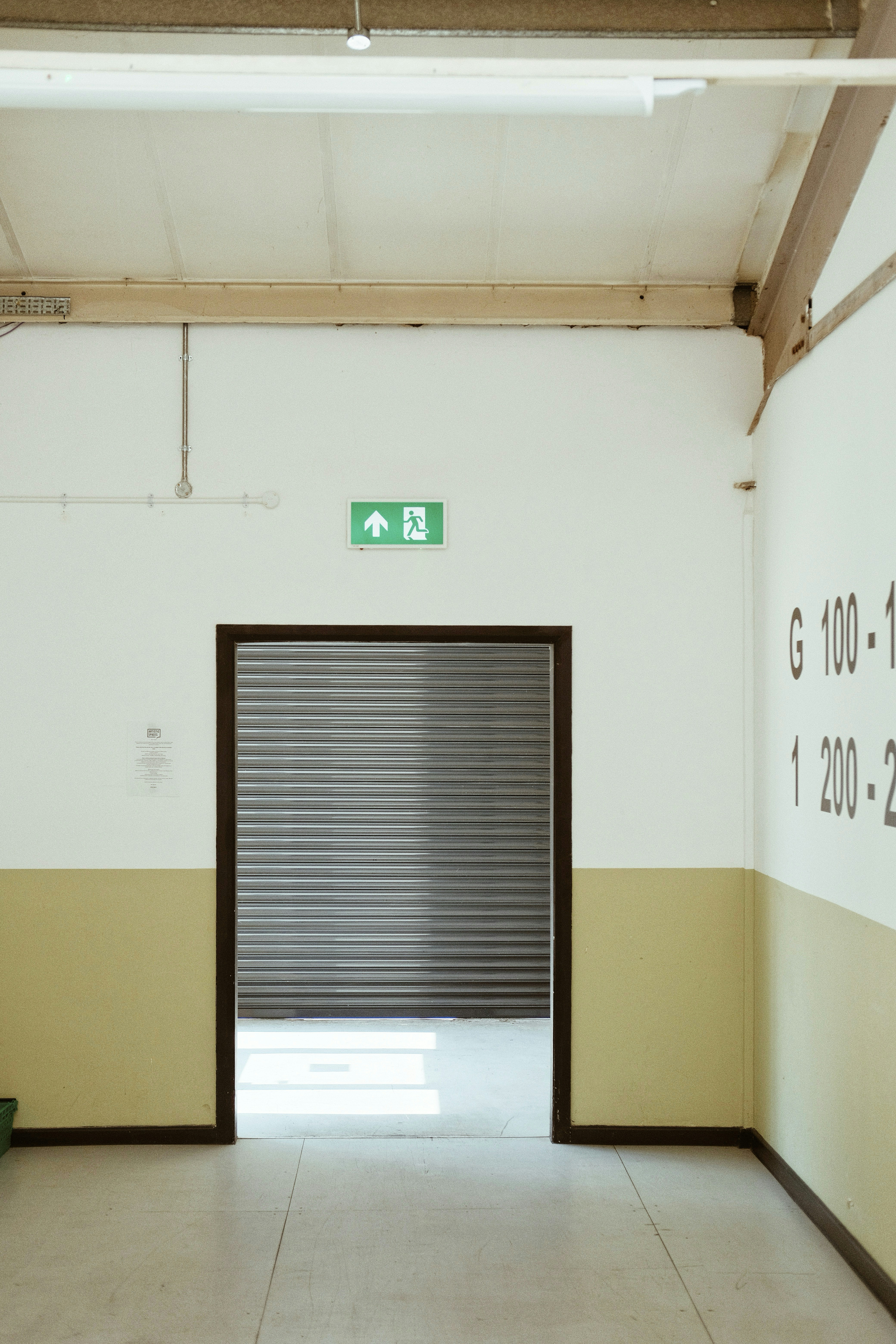 Industrial Exit: Pale Hallway Framed by a Rolling Door