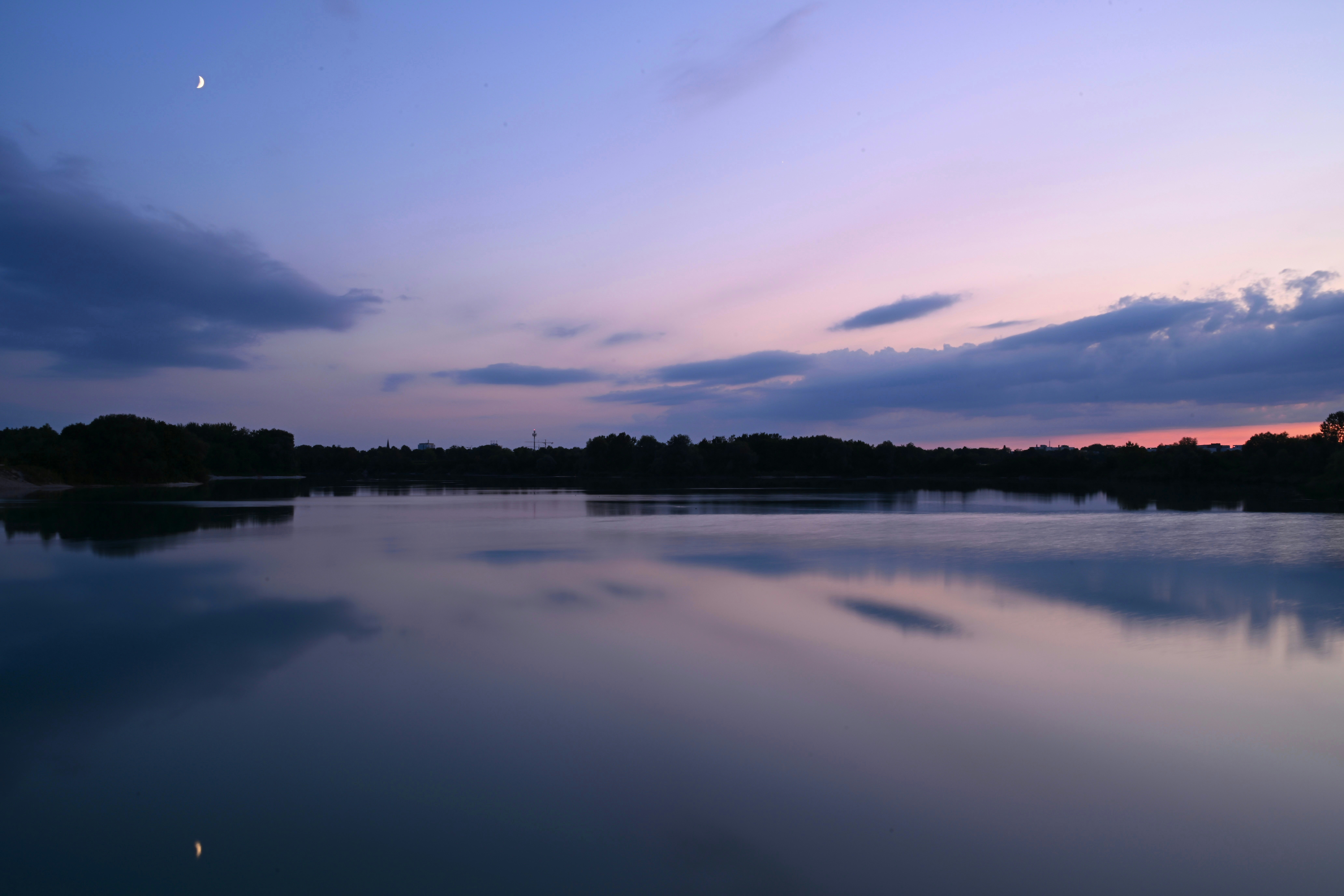 Dawn on the Quiet Lake: A Silent Sky Reflects a Moon and Horizon