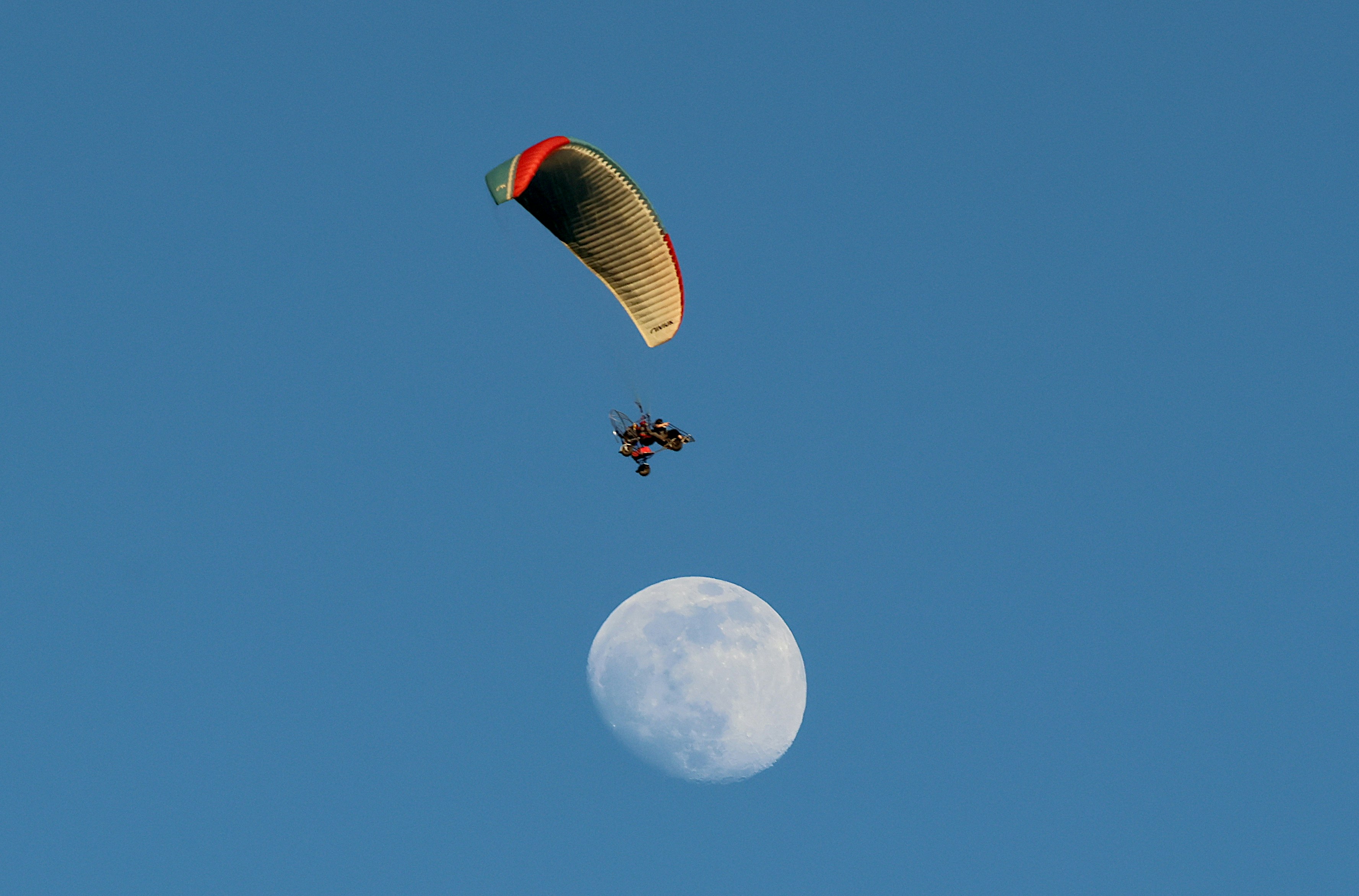 Landing Phantom: Paraglider Silhouette Over a Moonlit Sky