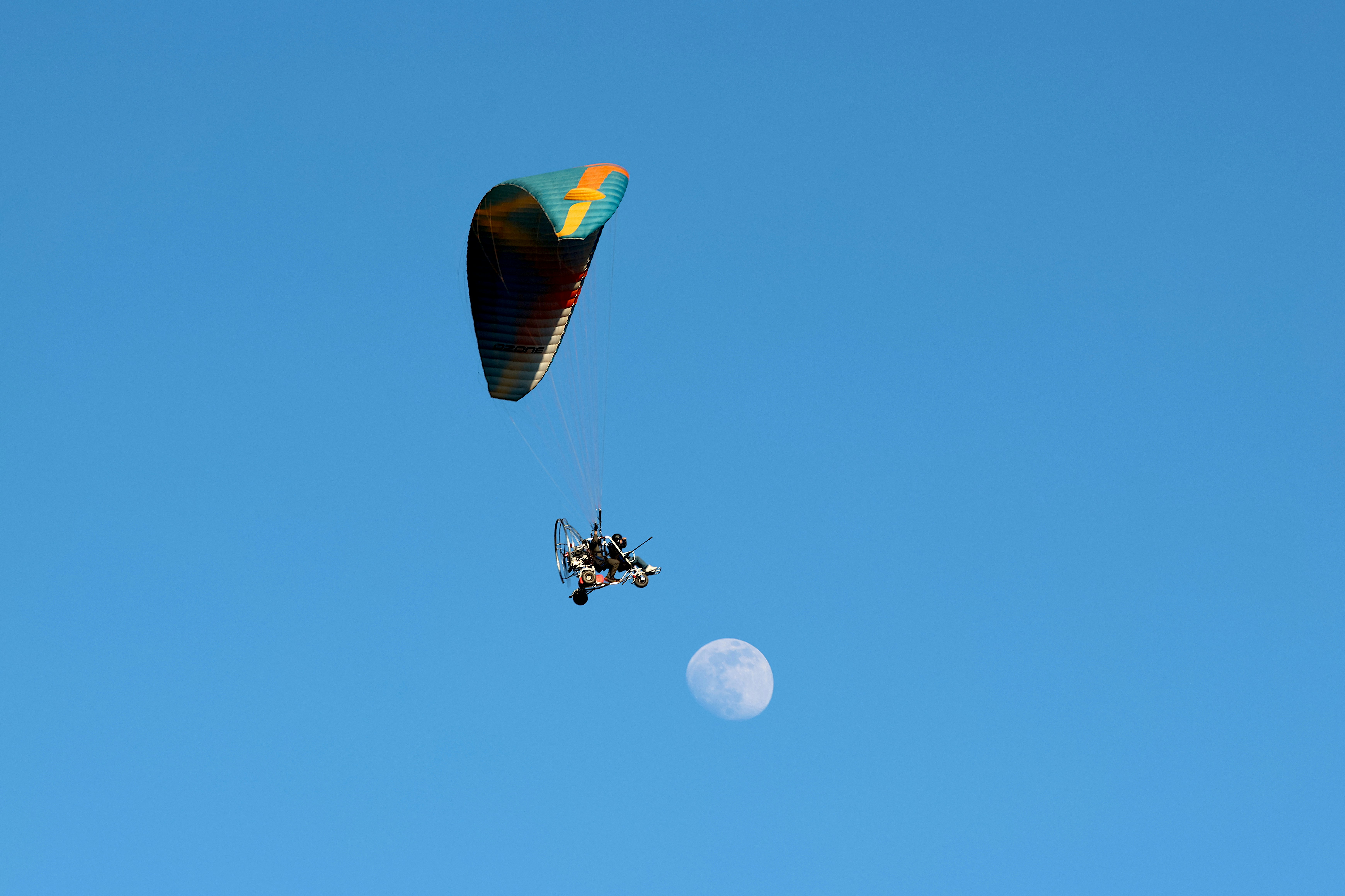 Blue Sky Dance: Paraglider Above the Moonlit Gap