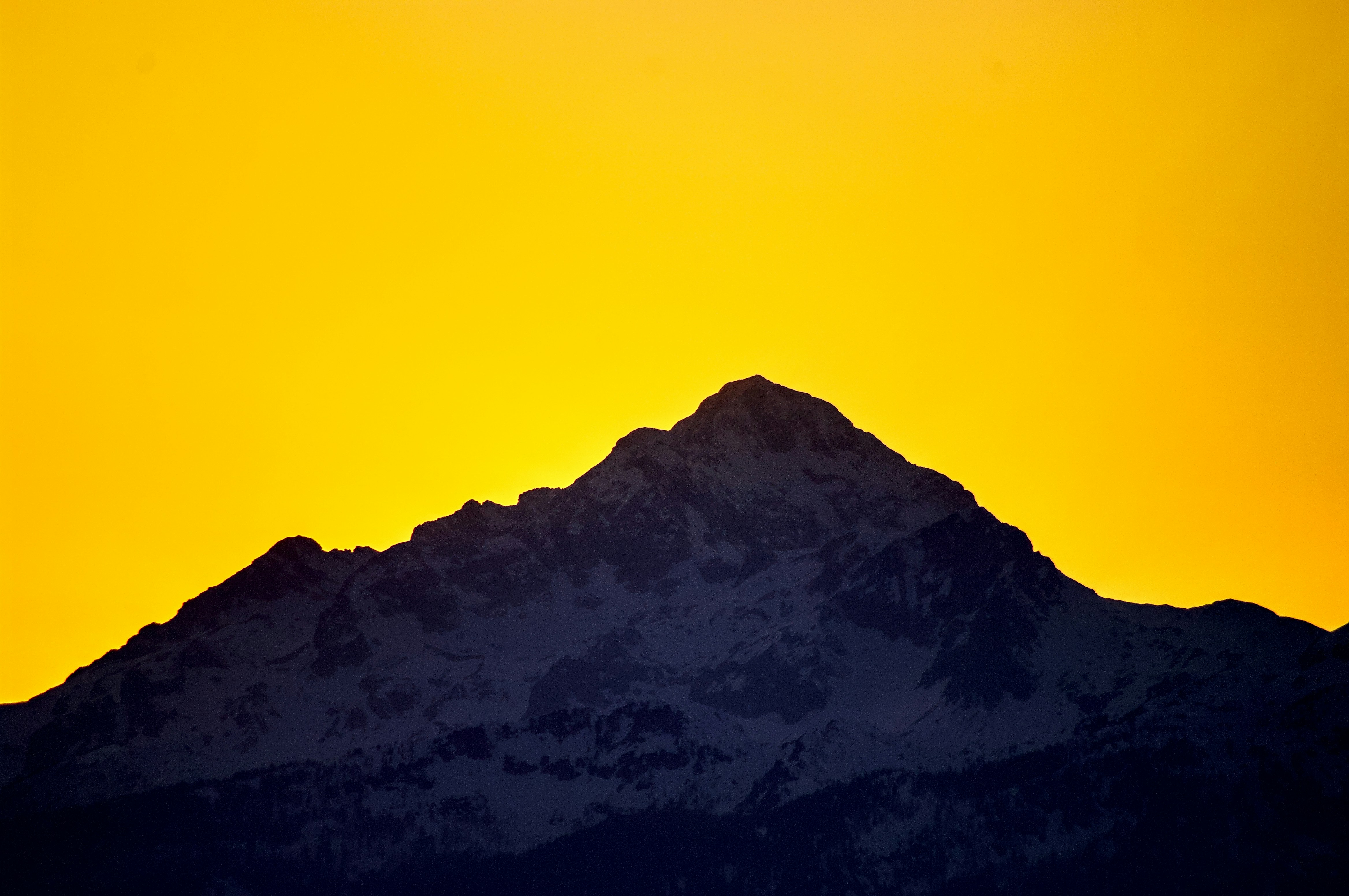 Silhouette Crown: A Mountain Peak Against a Solar Hue