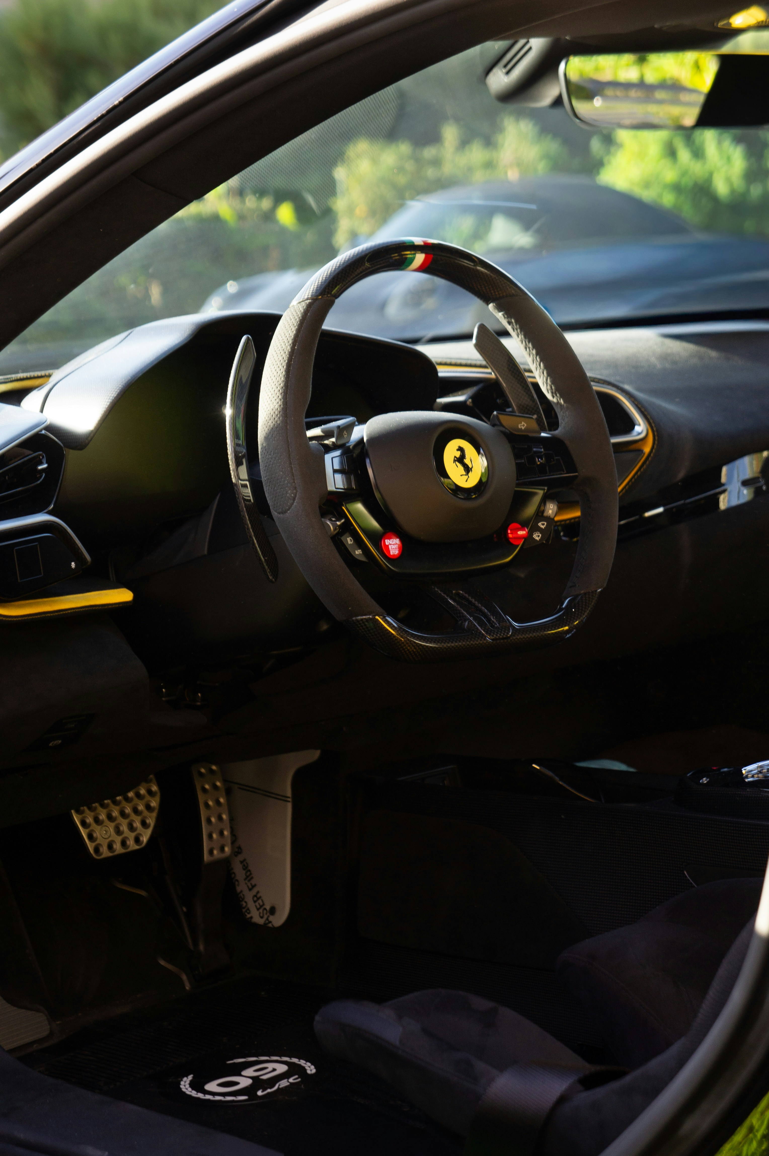 Ferrari cockpit: steering wheel centerpiece in sunlit interior