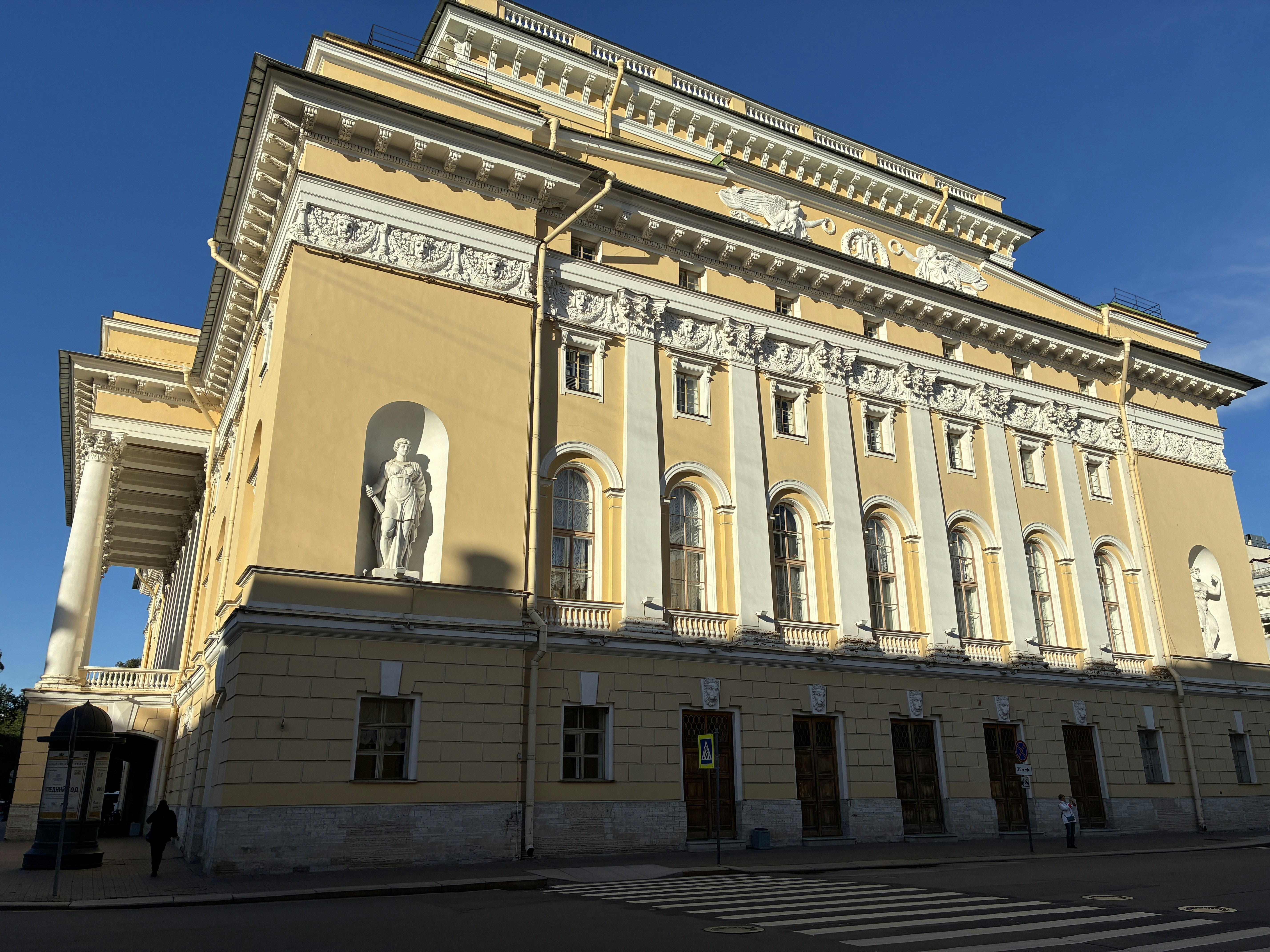 Sunlit Neoclassical Facade: A Tapestry of Columns and Statues