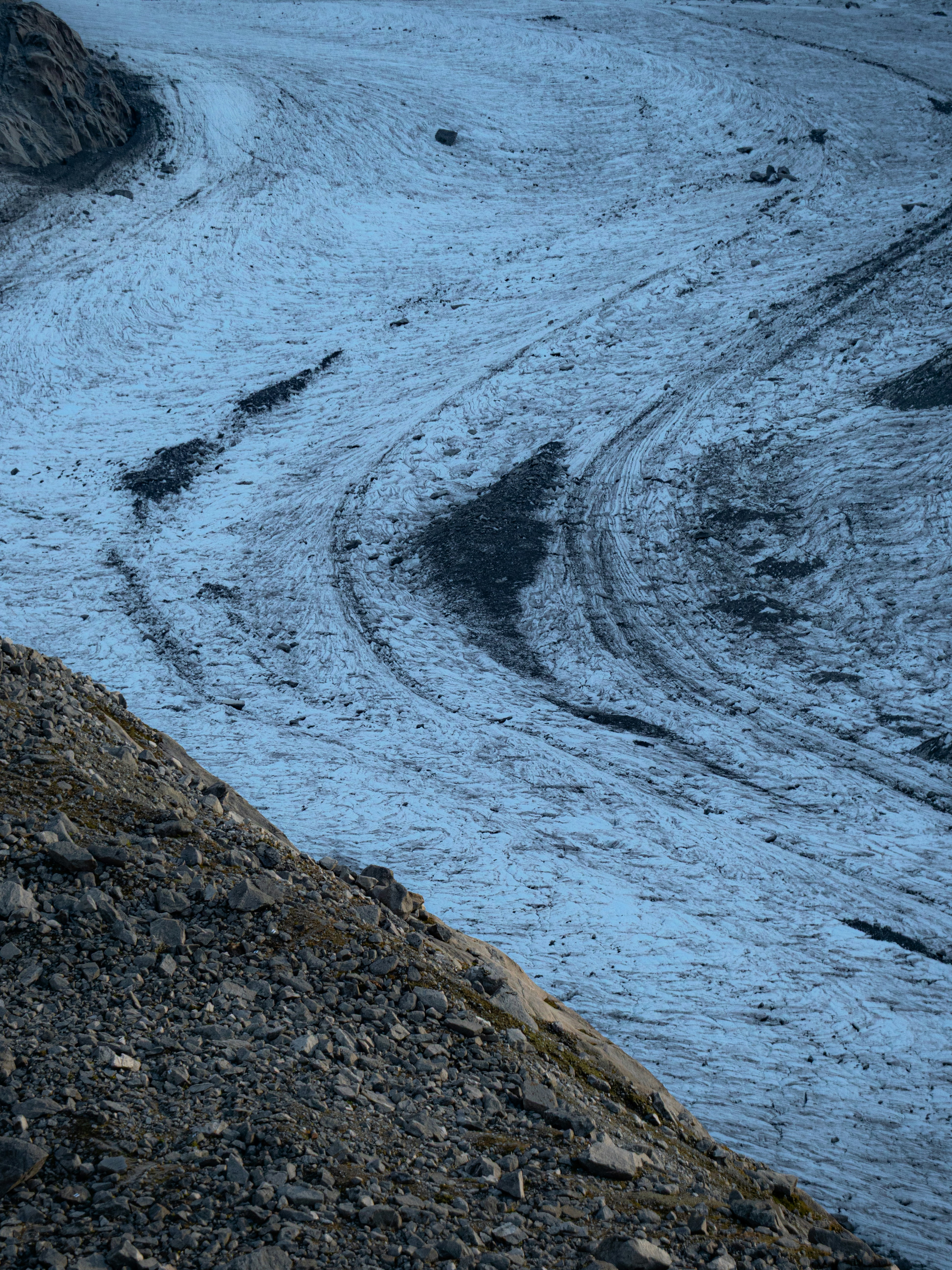 Glacial Skim: A Dark Shoreline of Snow and Rock