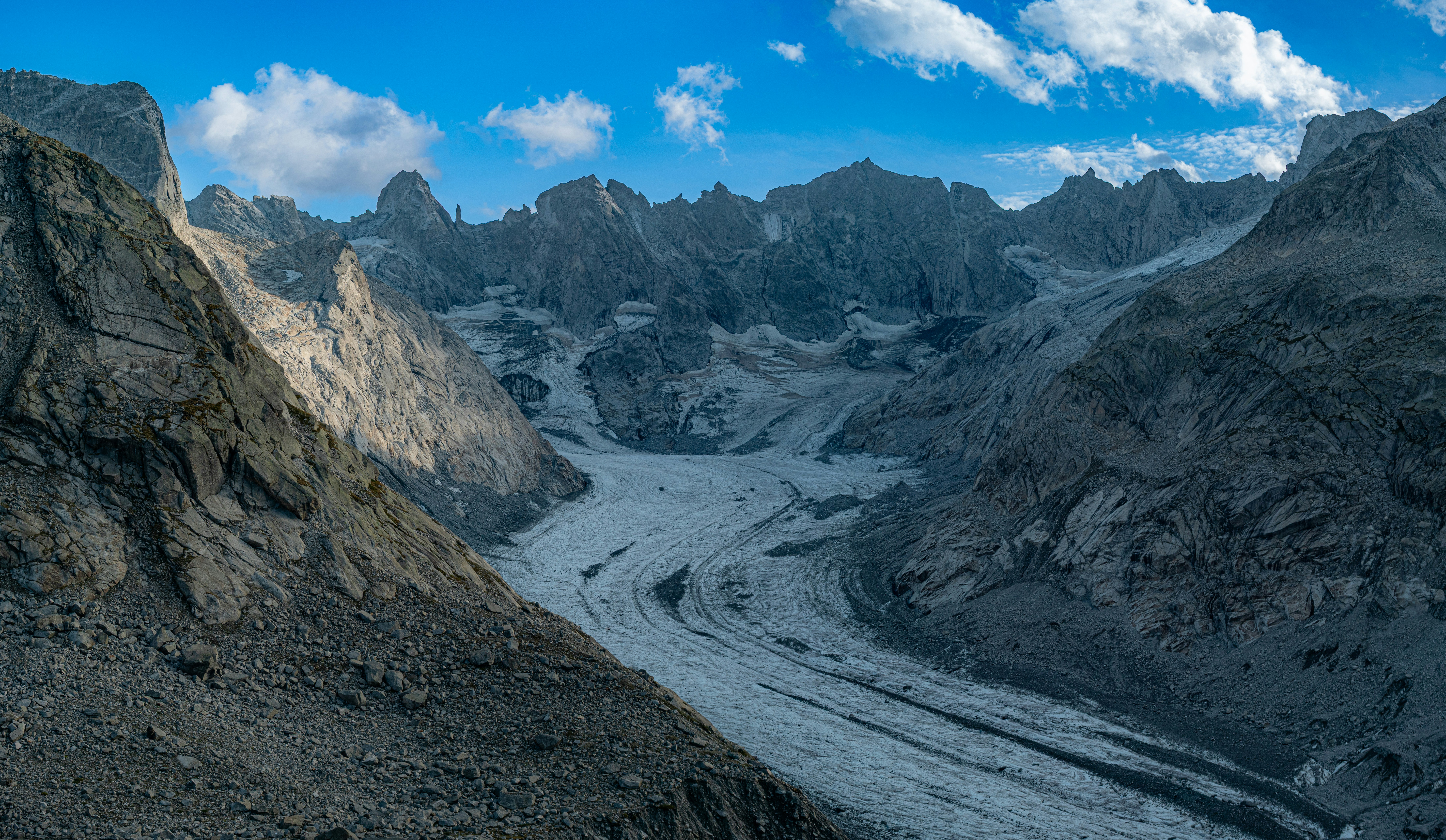 Glacial Valley Confronting Jagged Peaks Beneath a Bright Sky