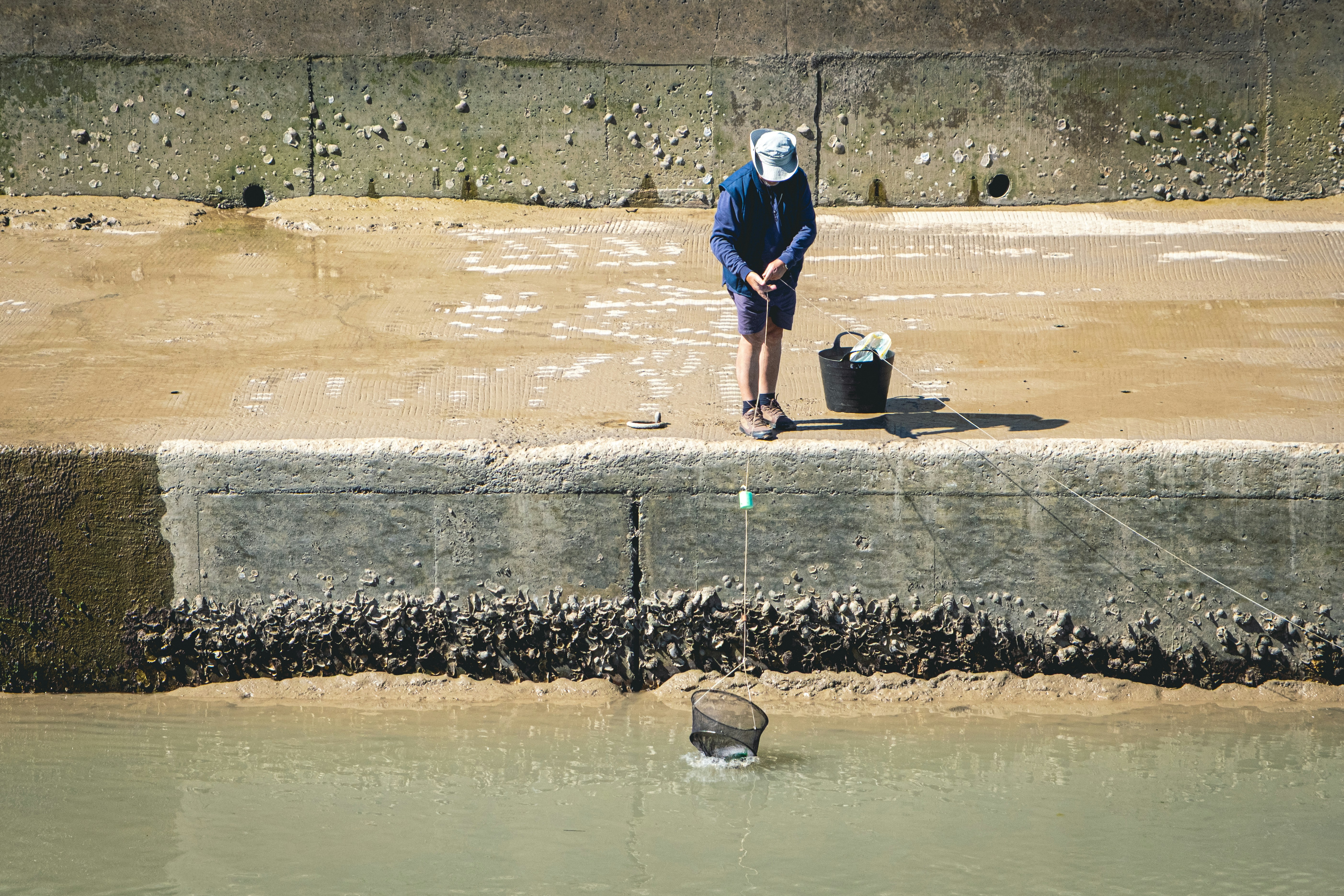 The Quiet Breakwater: Angler at the Edge of Tide