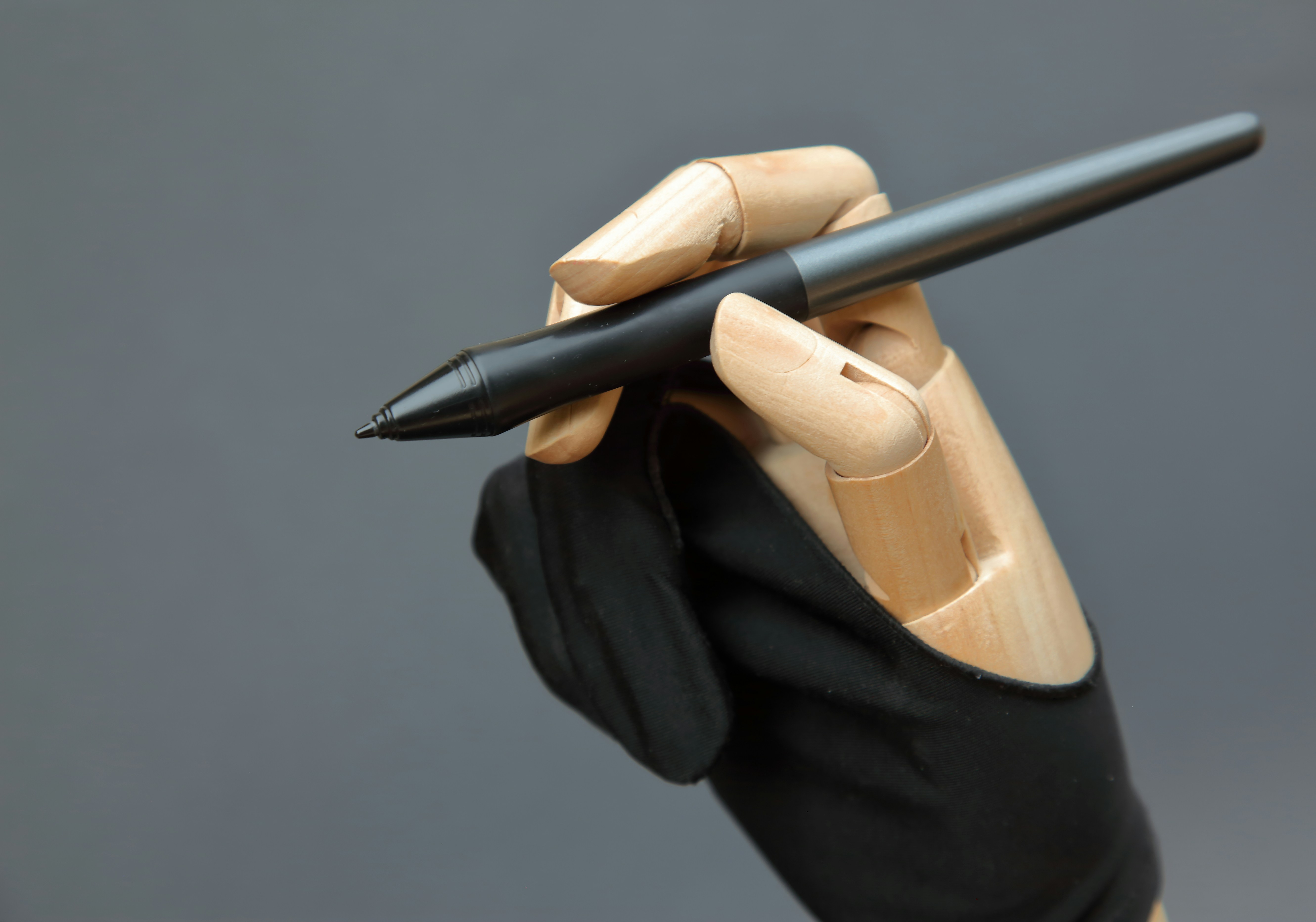 The Pen that Shapes a Sketch: A Gloved Hand Gripping a Stylus