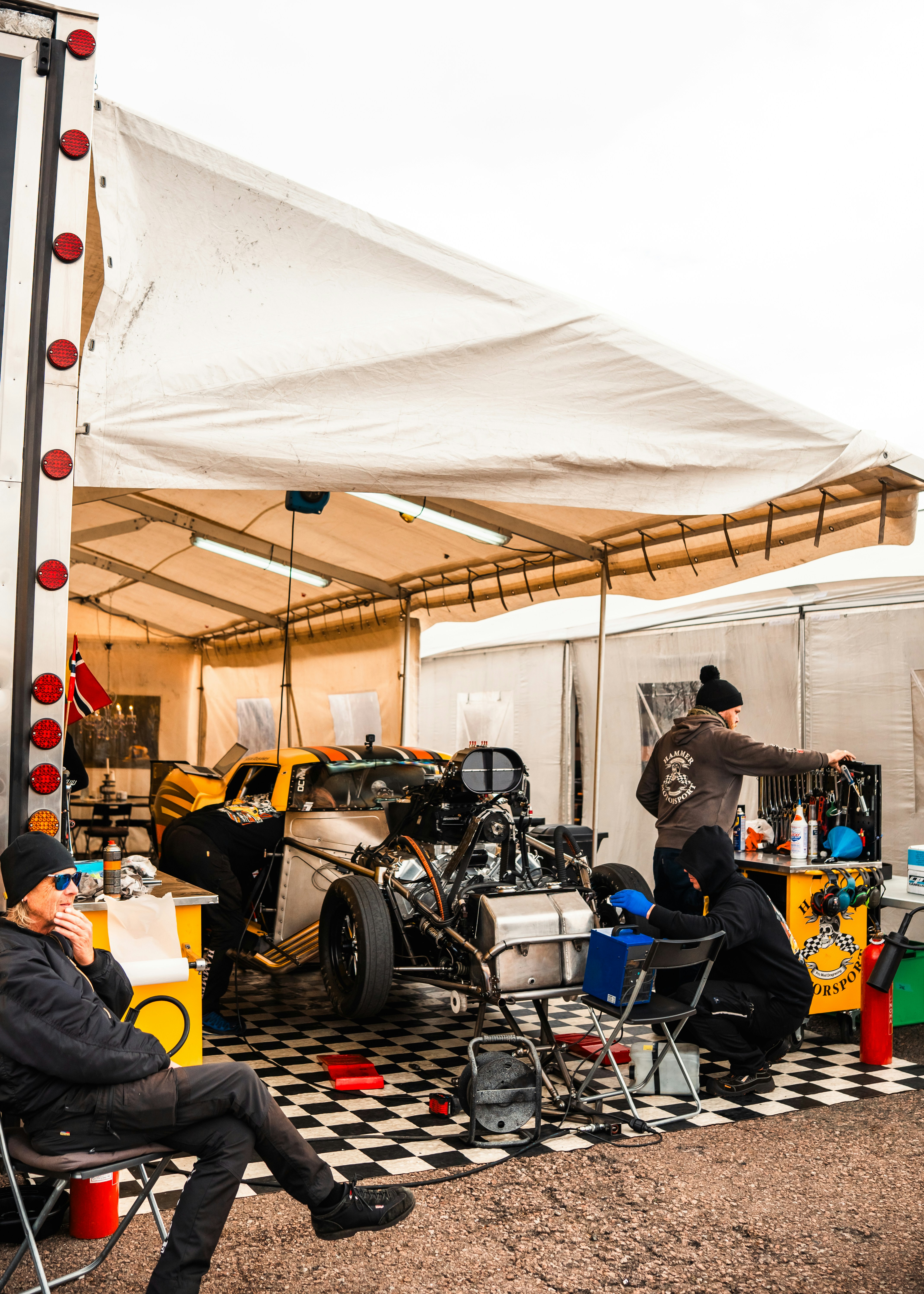 Mid-Pit Garage: The Pit Crew at Work Under a White Tent