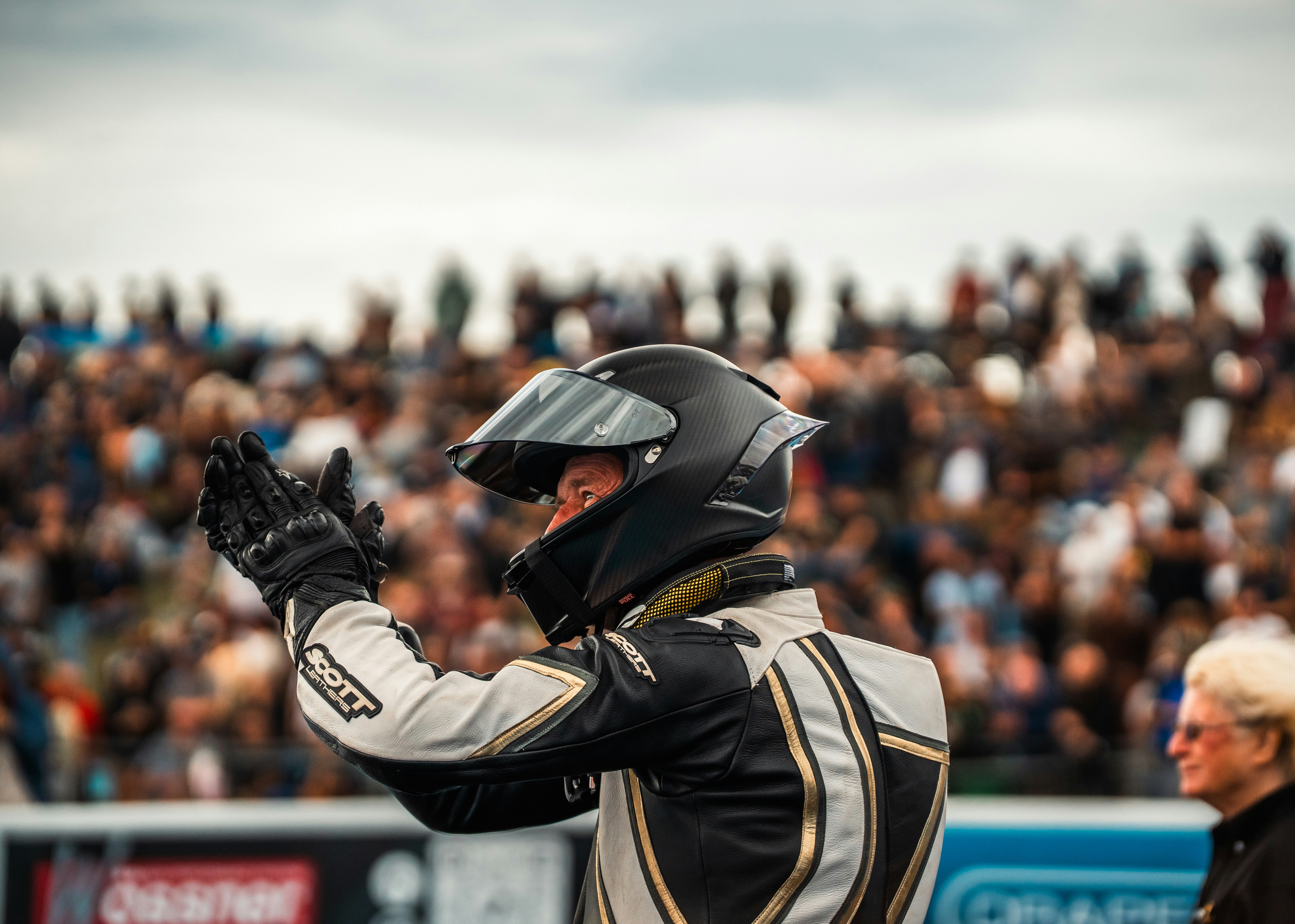 Helmeted Racer Salutes the Crowd