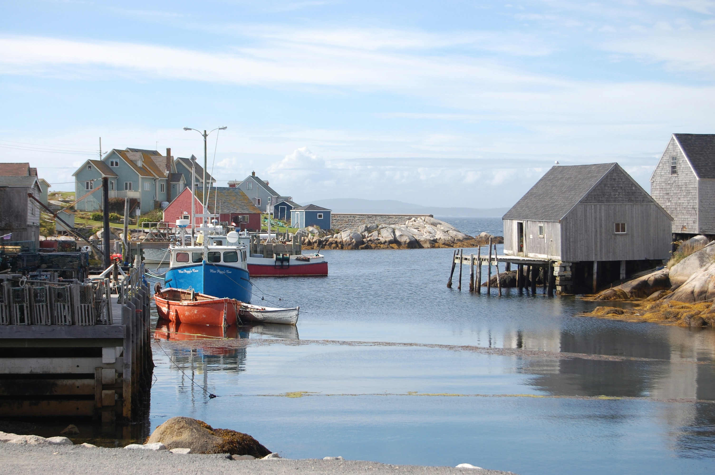 Quiet harbor with colorful cottages and boats at the edge of calm water