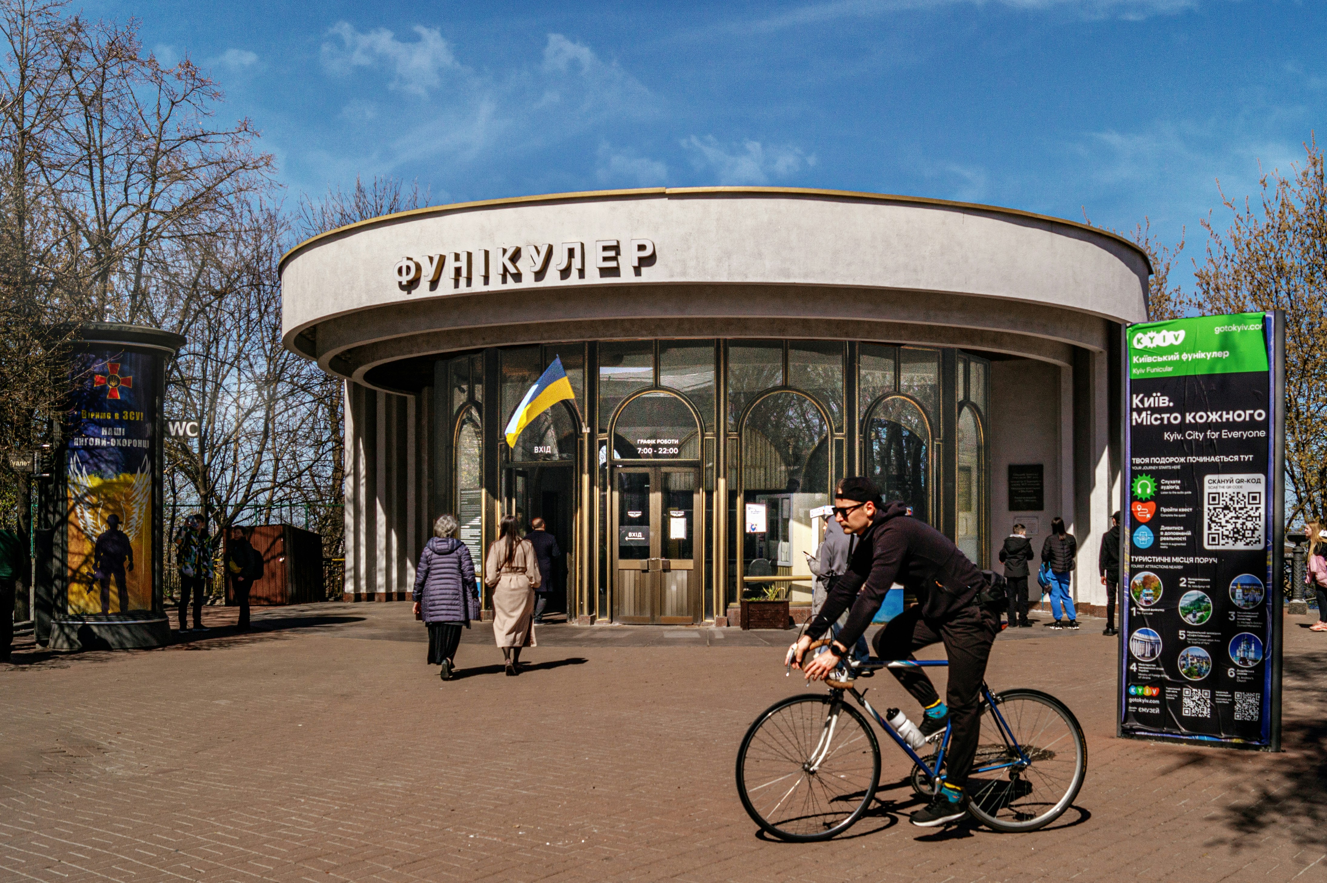 Cyclist in Focus: A City Entrance Framed by Architecture and Kyiv Flag