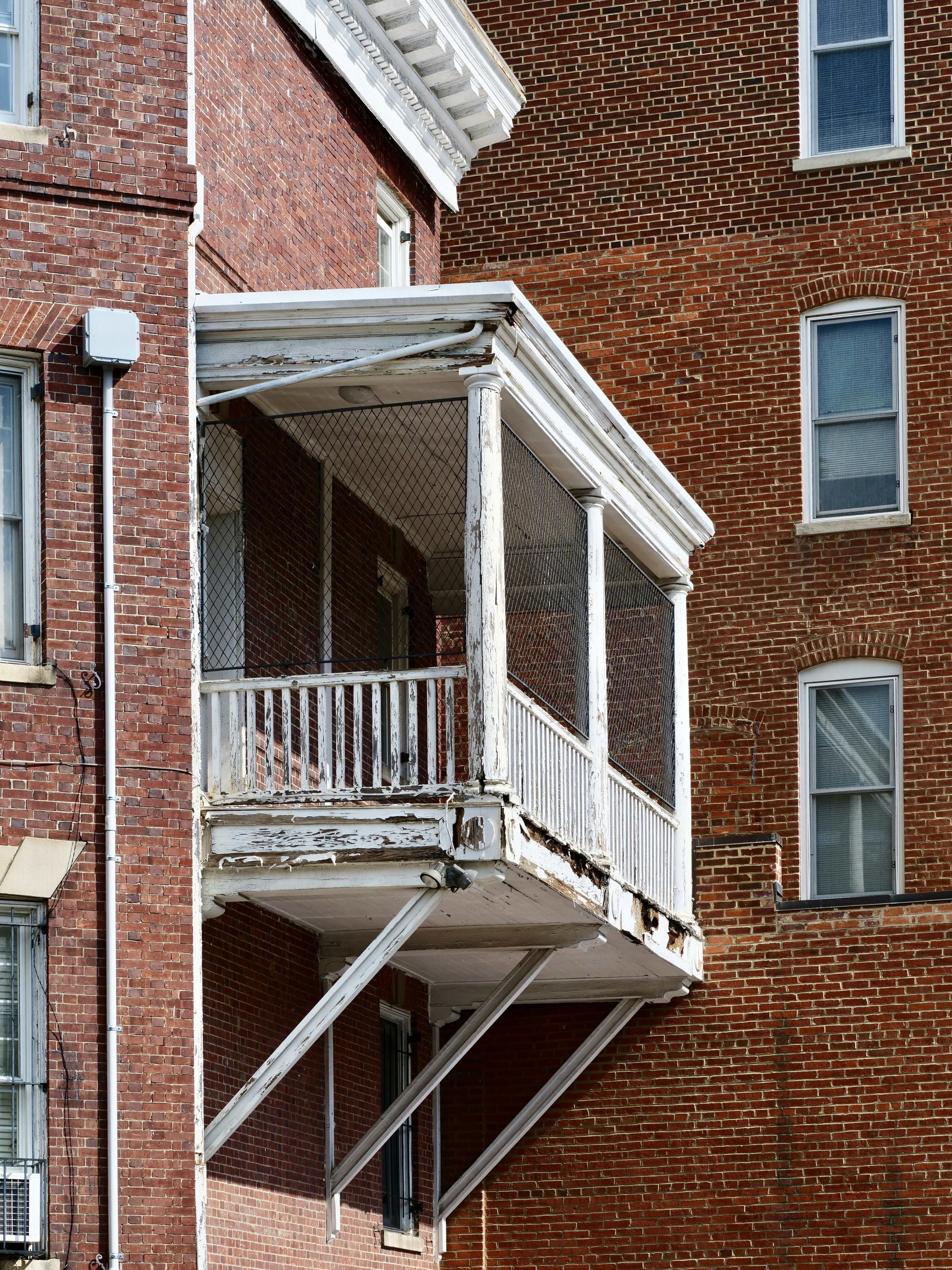 Weathered Balcony Cloaked in Brick and Light