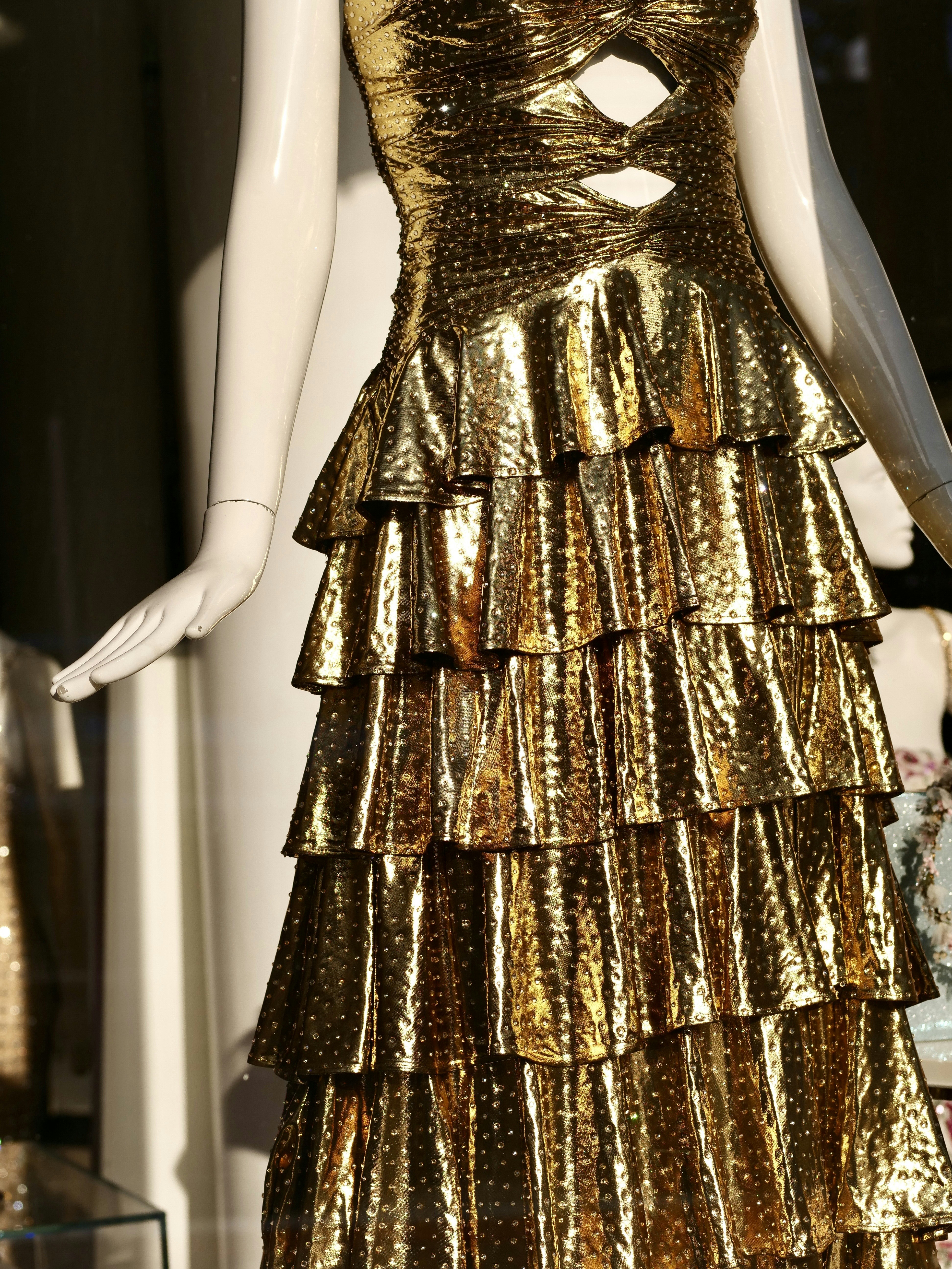 Gilded Waves: Tiered Gold Dress on a Minimalist Mannequin