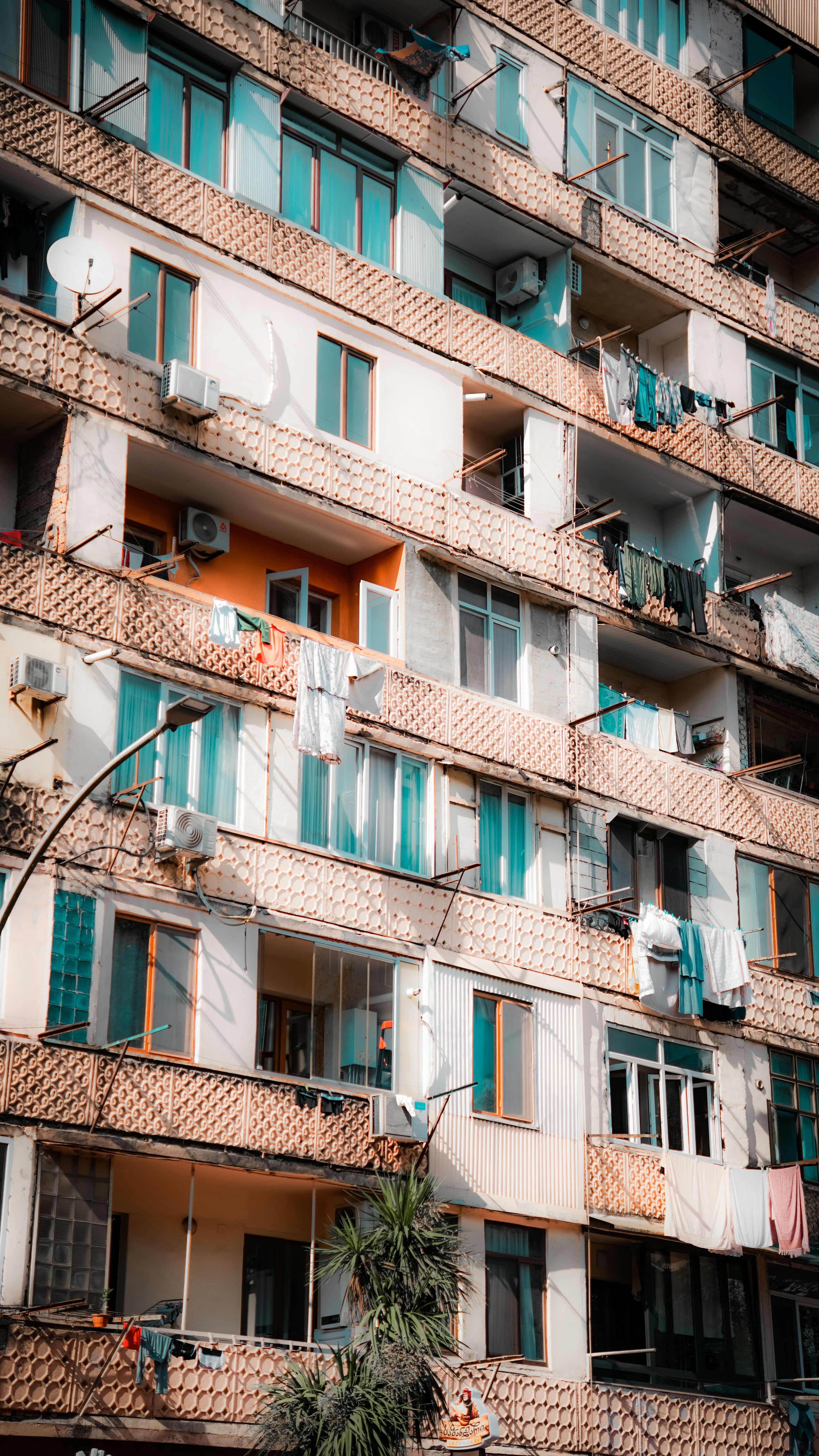 A multi-story apartment building with balconies and laundry hanging on lines