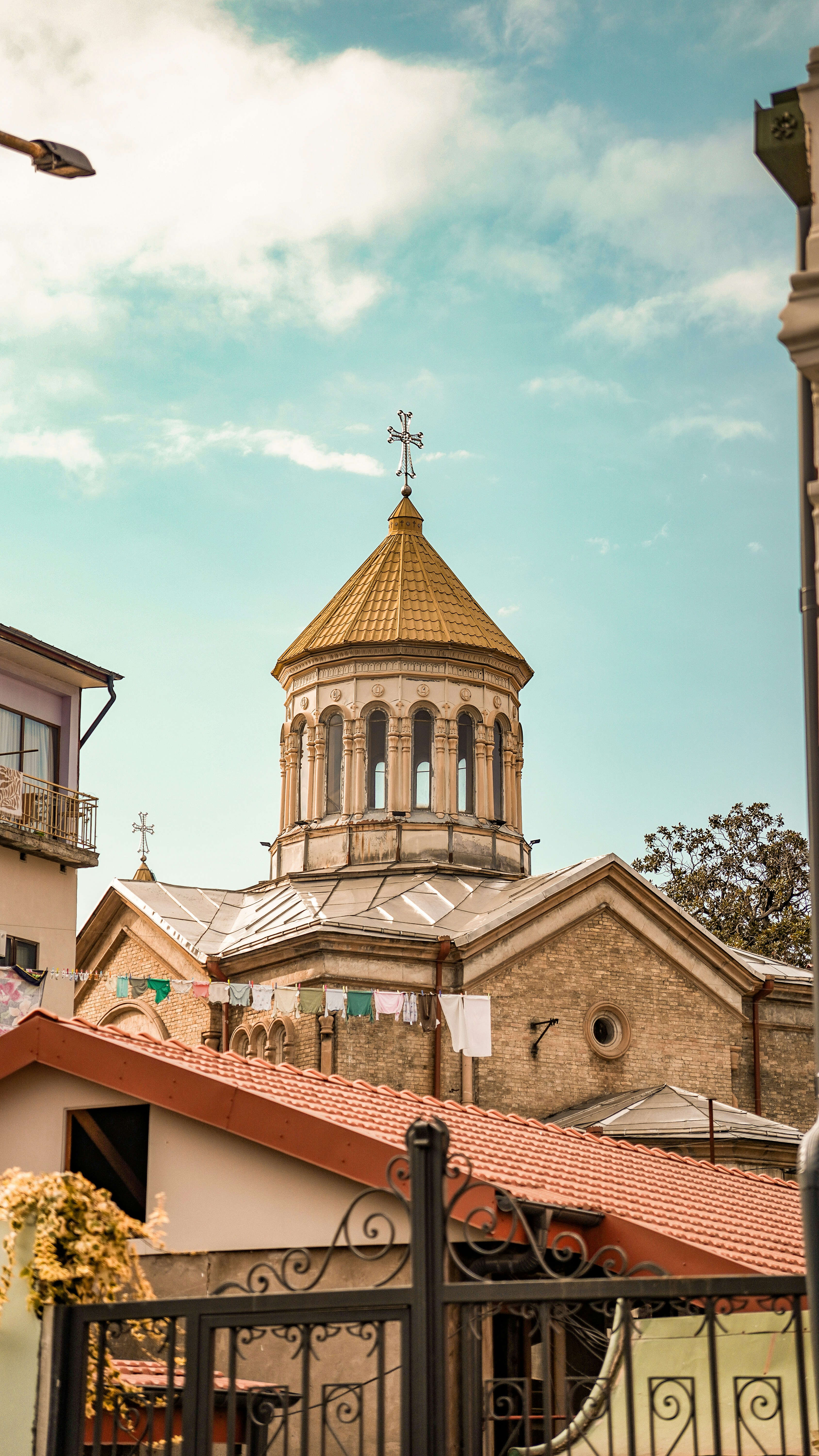 A church with a golden dome and a cross against a blue sky