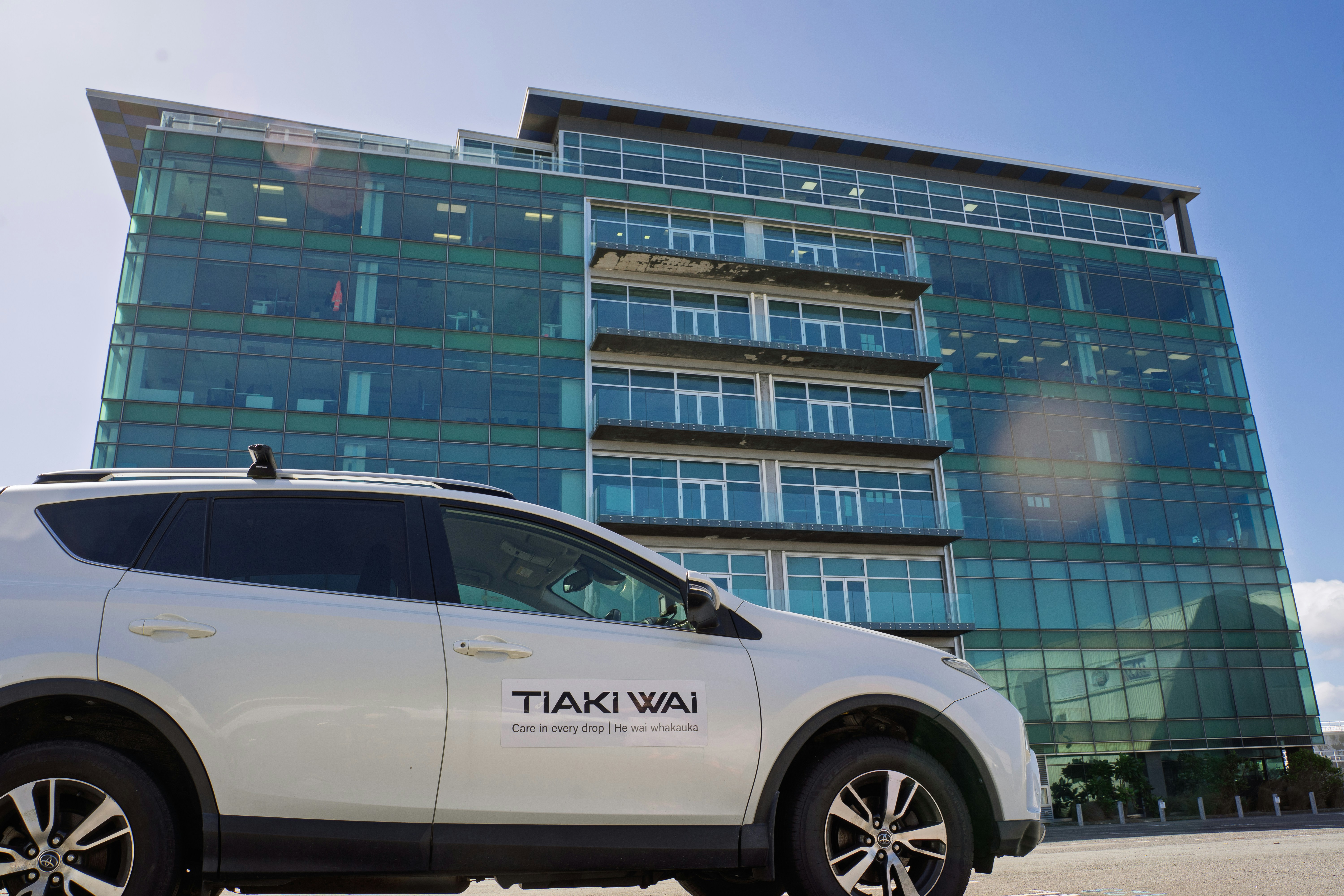 Corporate Drive: White SUV in Front of Modern Glass Office Building