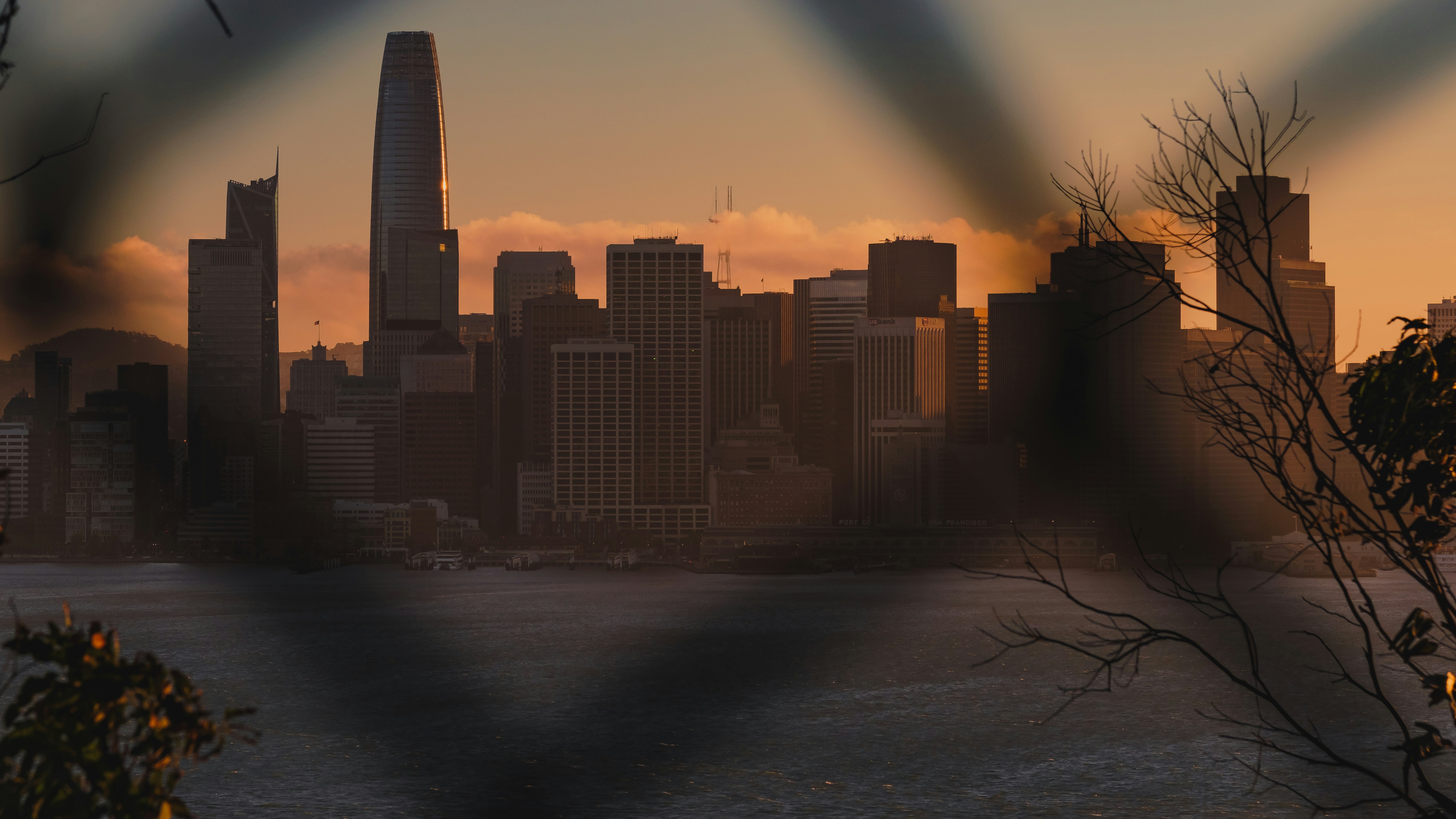 Sunset Silhouette Over a Fogged Waterfront Skyline