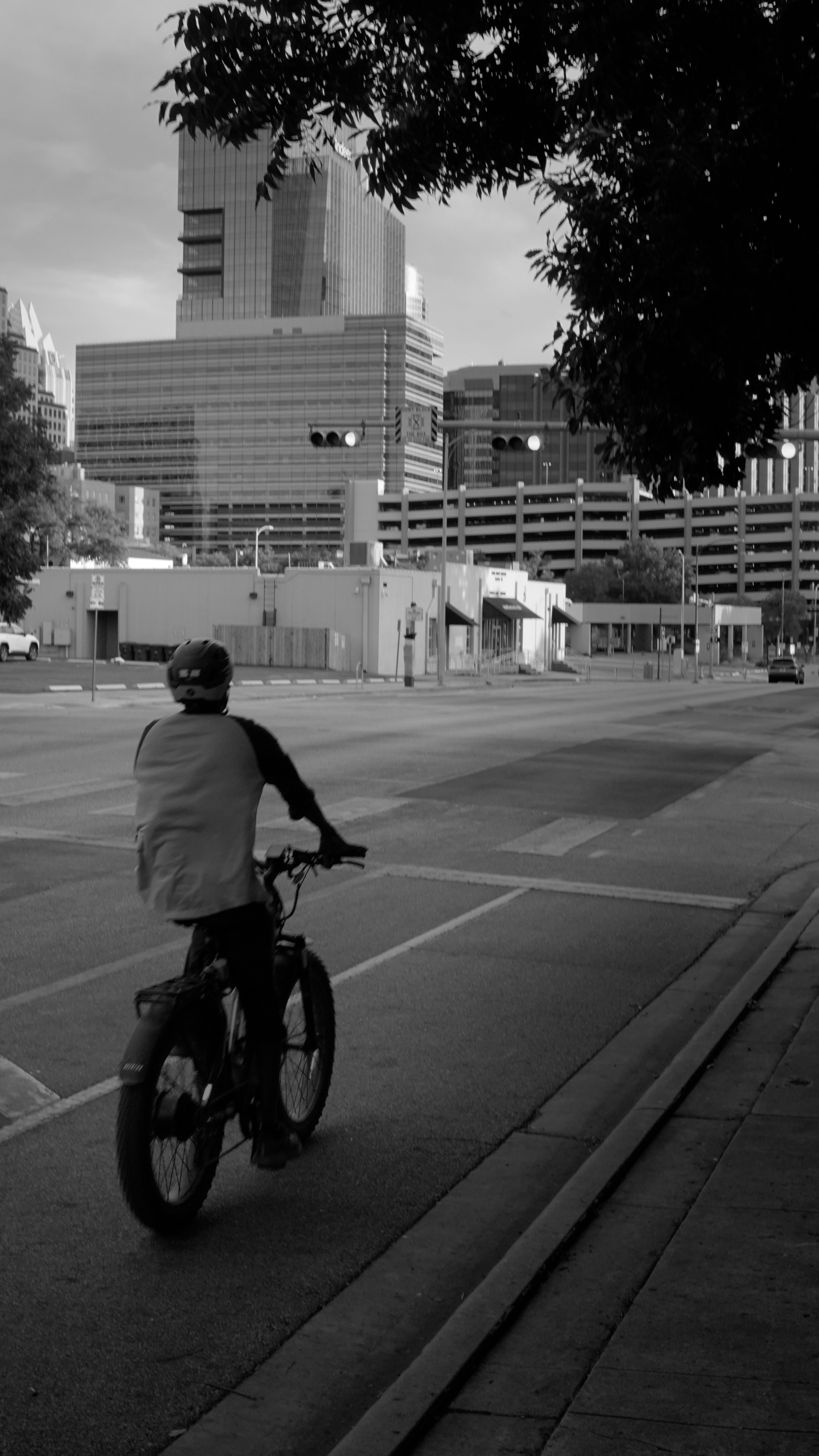 Rider Entering the City: A Quiet Ascent Past Skyward Glass