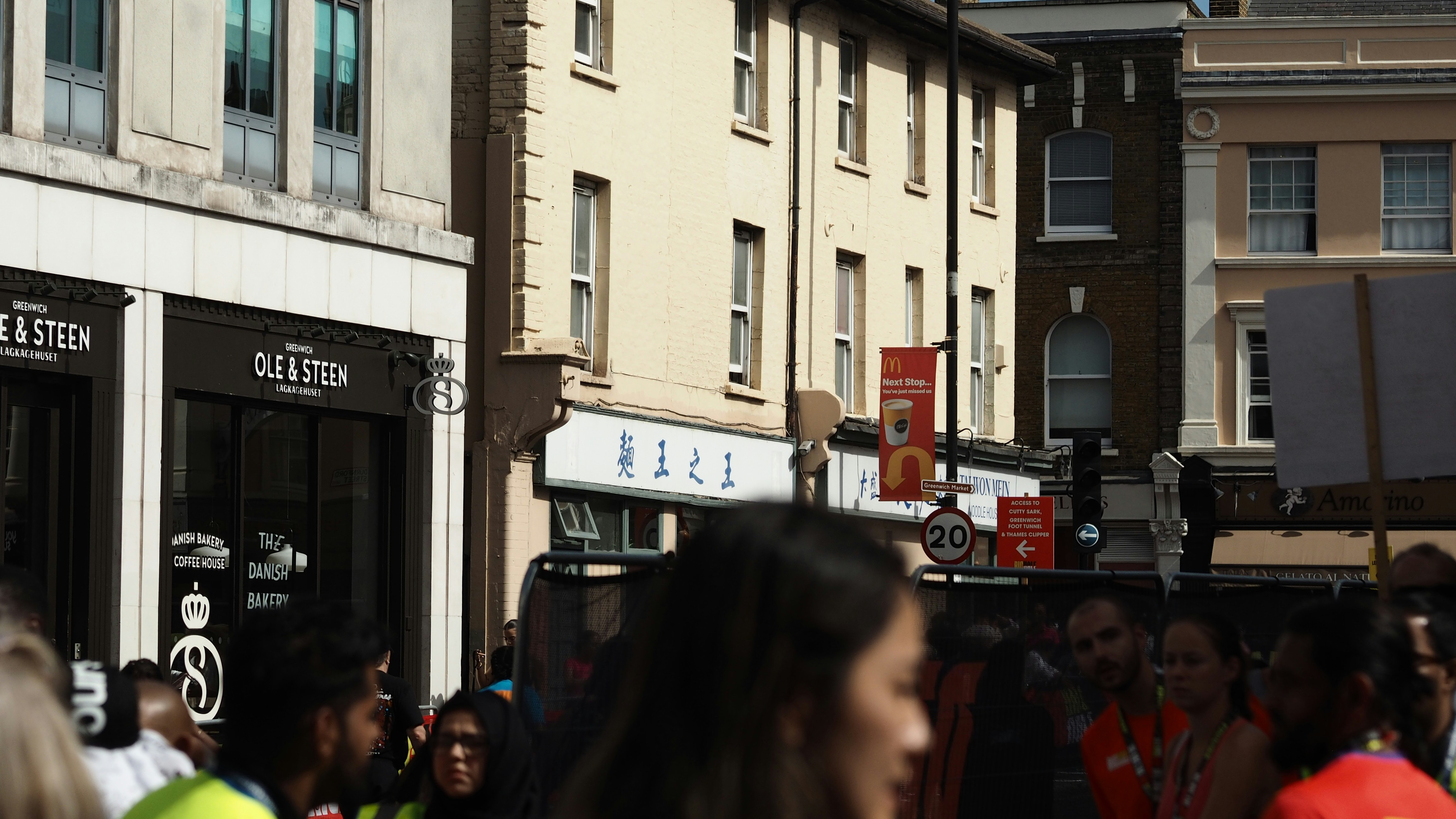 Crowded street scene with shopfronts and blurred pedestrians