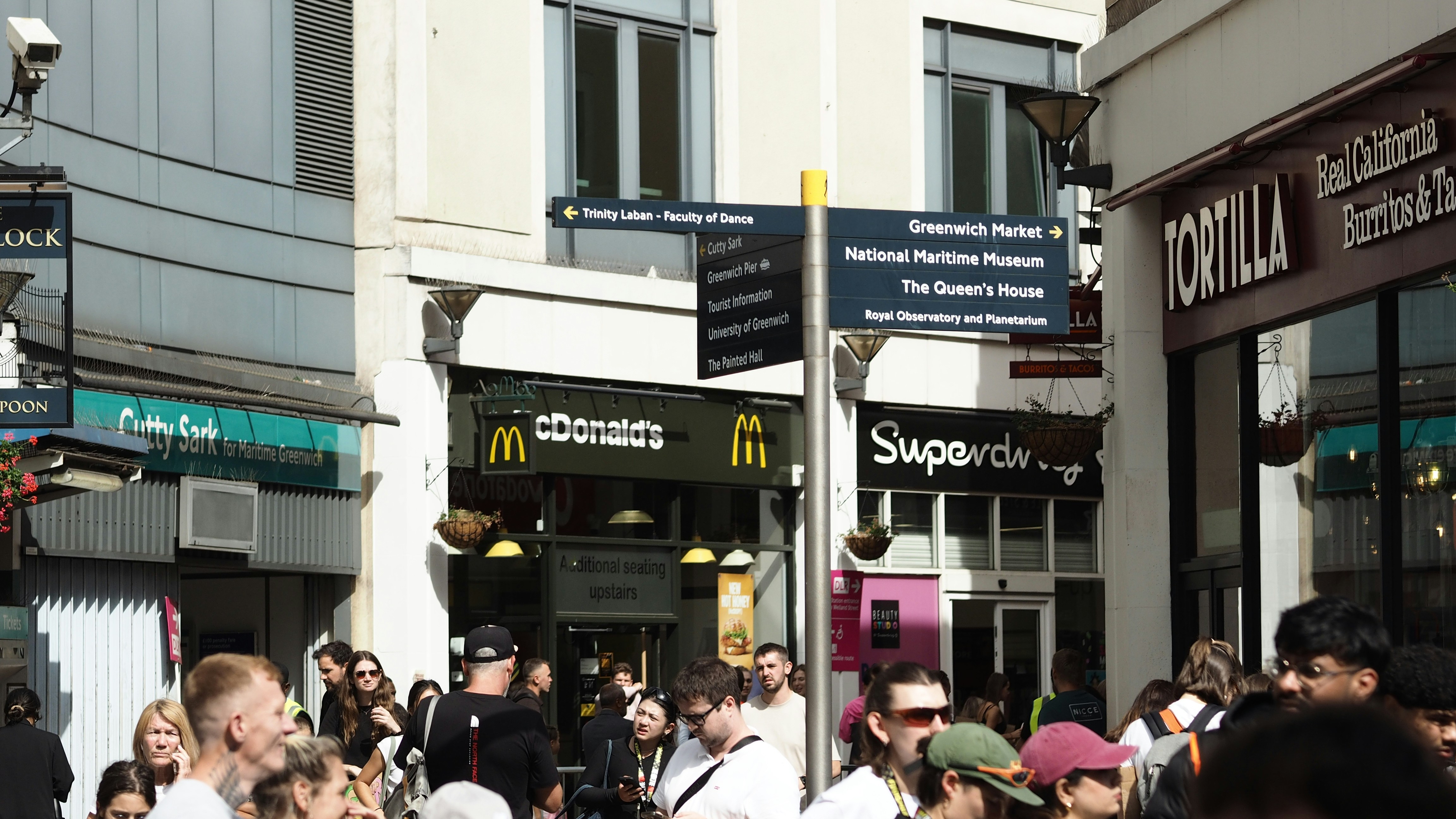 Crowded Street Corner with McDonald’s and Signage Beyond