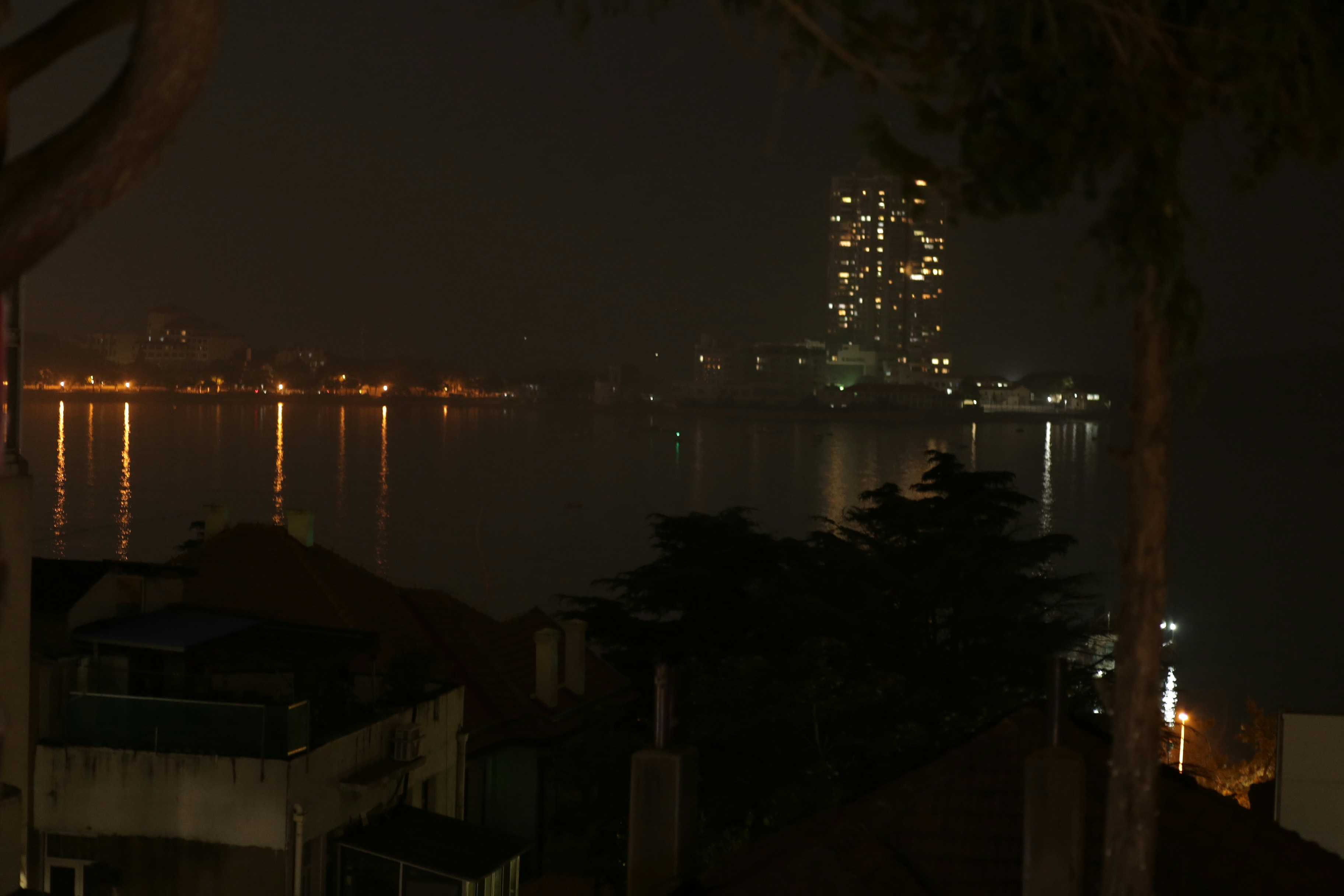 Midnight Harbor Lights: Quiet Waterfront Skyline Across Calm Water
