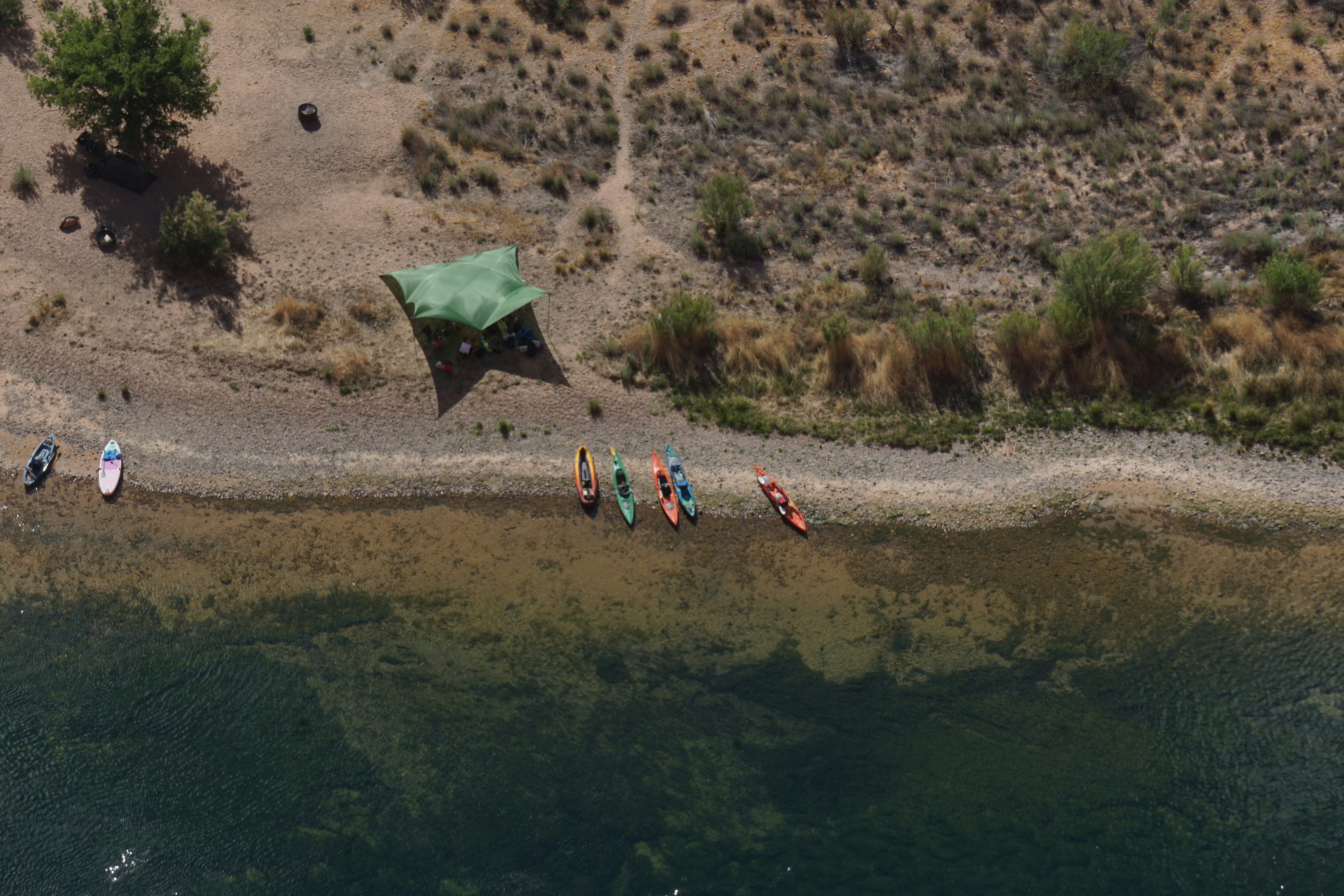 Shoreline Slack: Kayaks Resting Along a Quiet River Edge