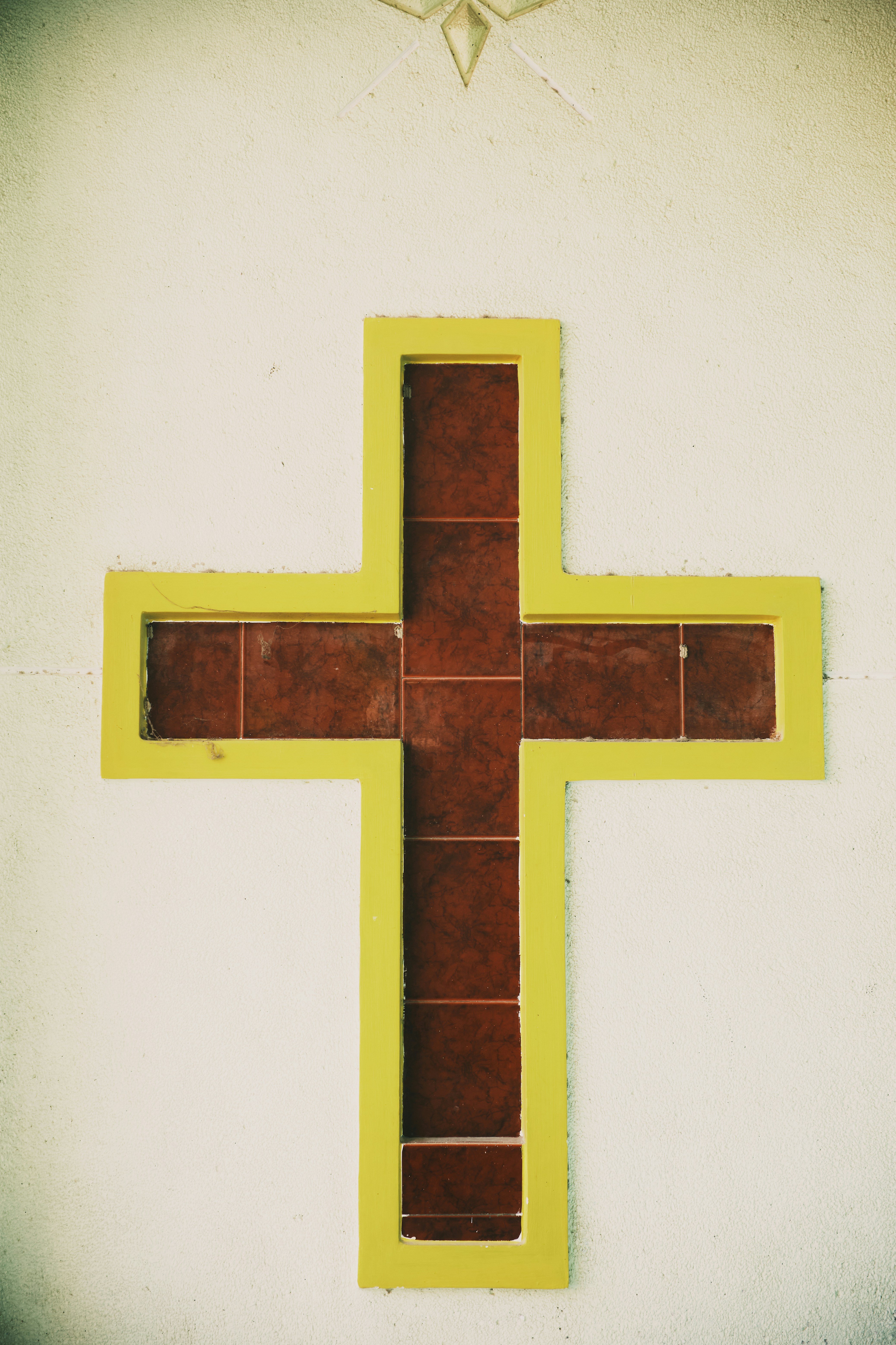 Yellow-edged Cross: A Tile-Tinted Emblem in Soft Focus