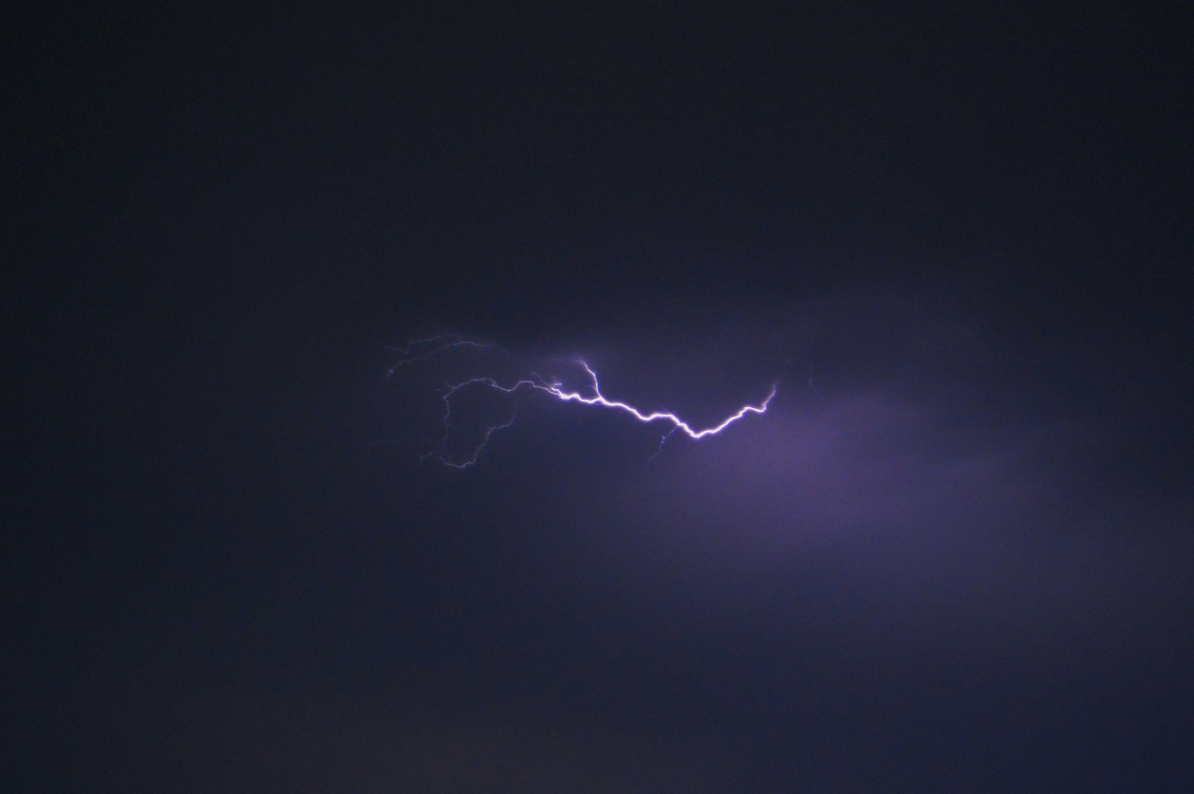 Pulse in the Night: A Luminous Sliver Among Clouds