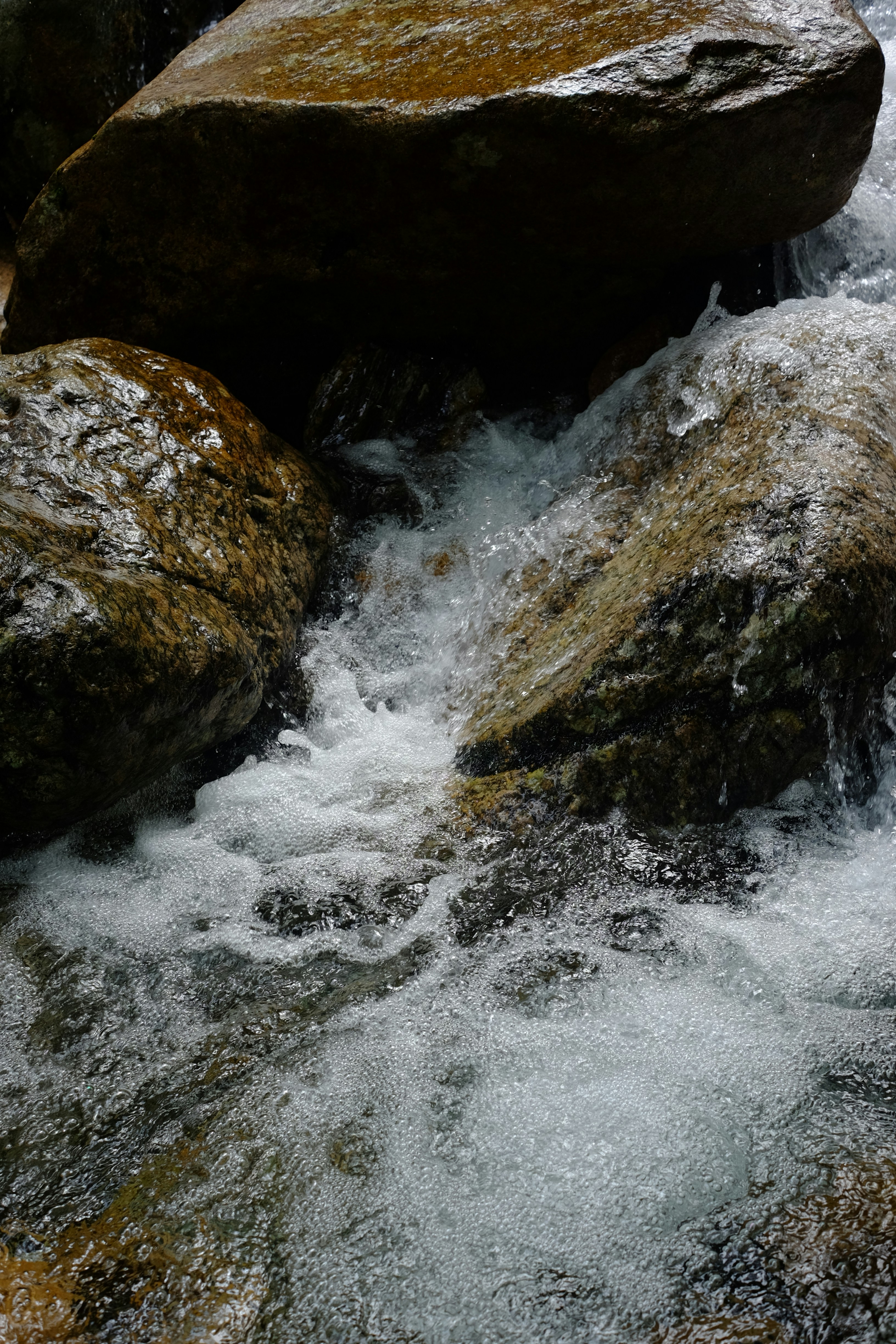 Rushing Moss and Stone: A Veiled Cascade Between Boulders