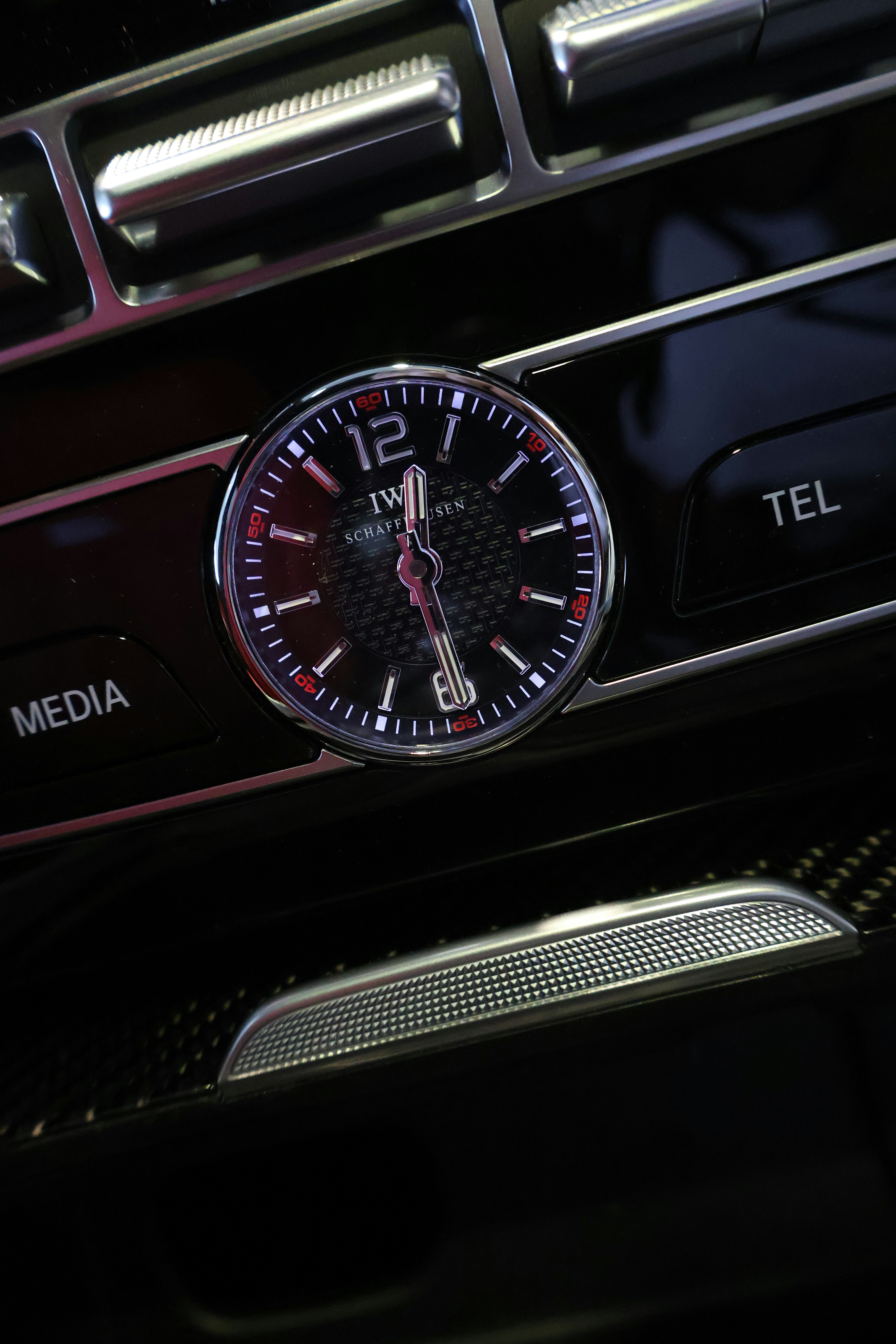 Chronograph on chrome: a luxury car clock embedded in glossy dashboard