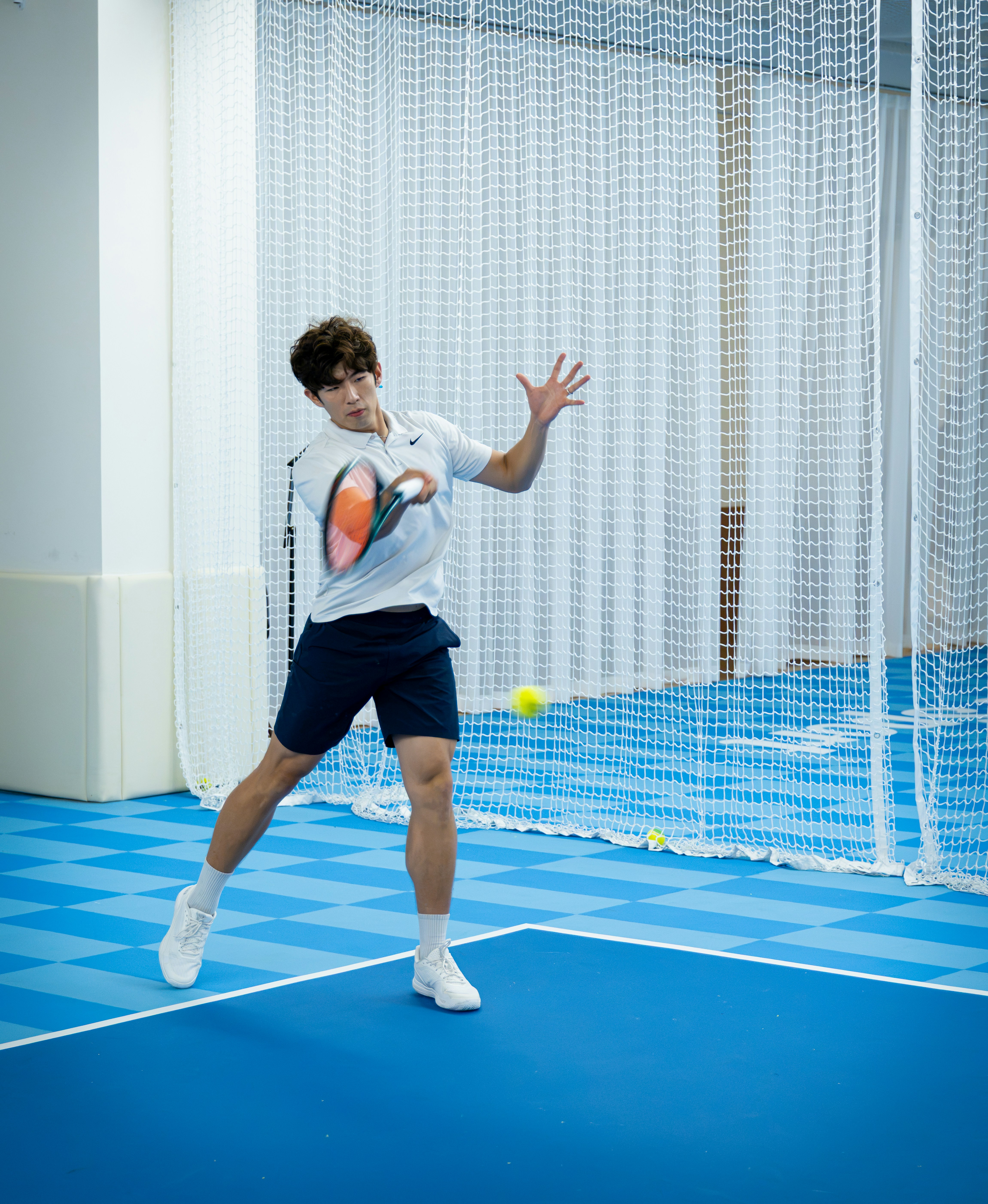 Dynamic Tennis Swing Beneath a Carved Curtain of Nets