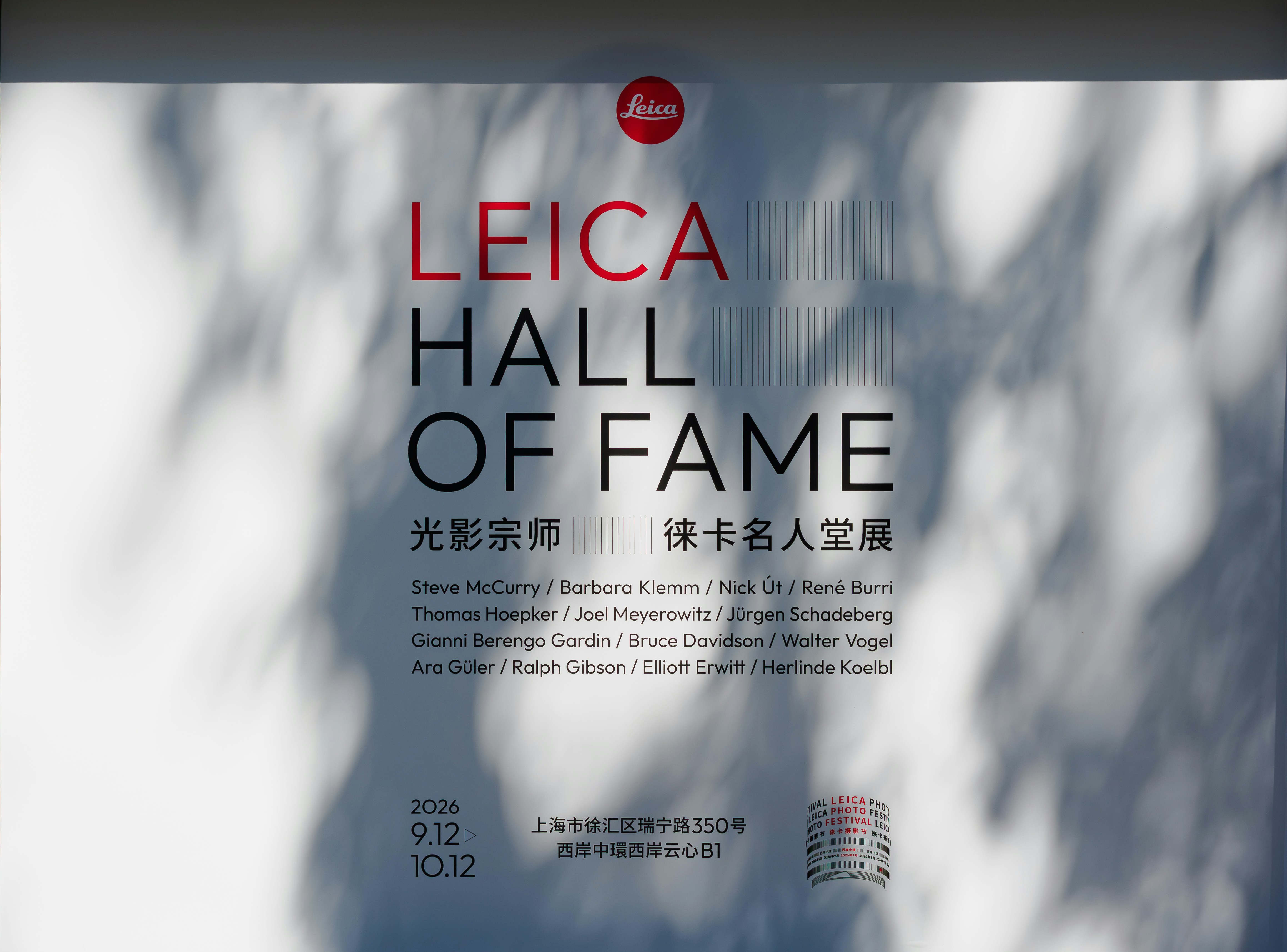 Prominent LEICA HALL OF FAME sign with shadowed branches creating abstract patterns across the text. A clean logo and list of names beneath the bold title, presented as a gallery signage.