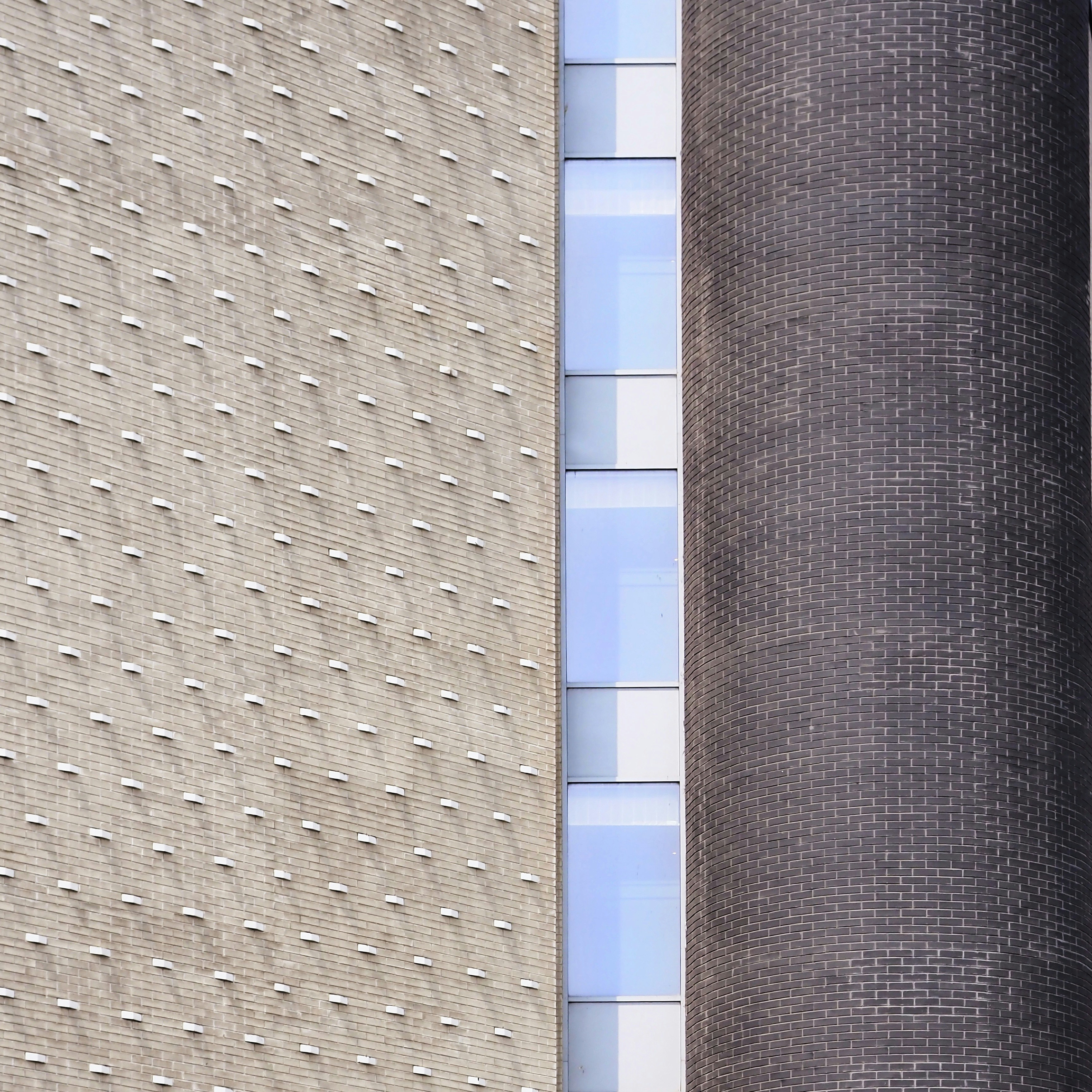 Vertical Contrast: Brick Facade Divided by Glass Stripe