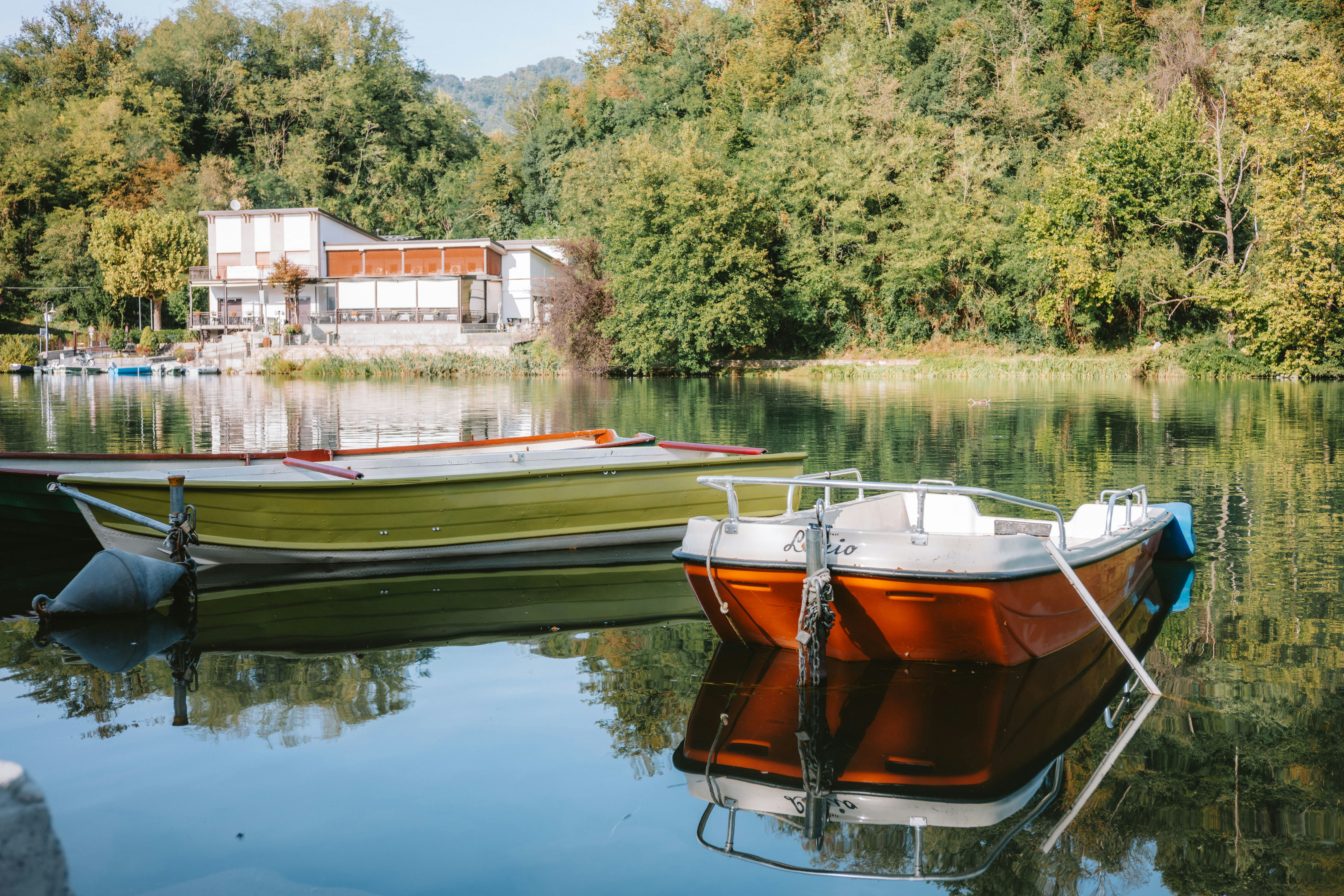 Docked Boats on a Quiet Lake with a Riverside House