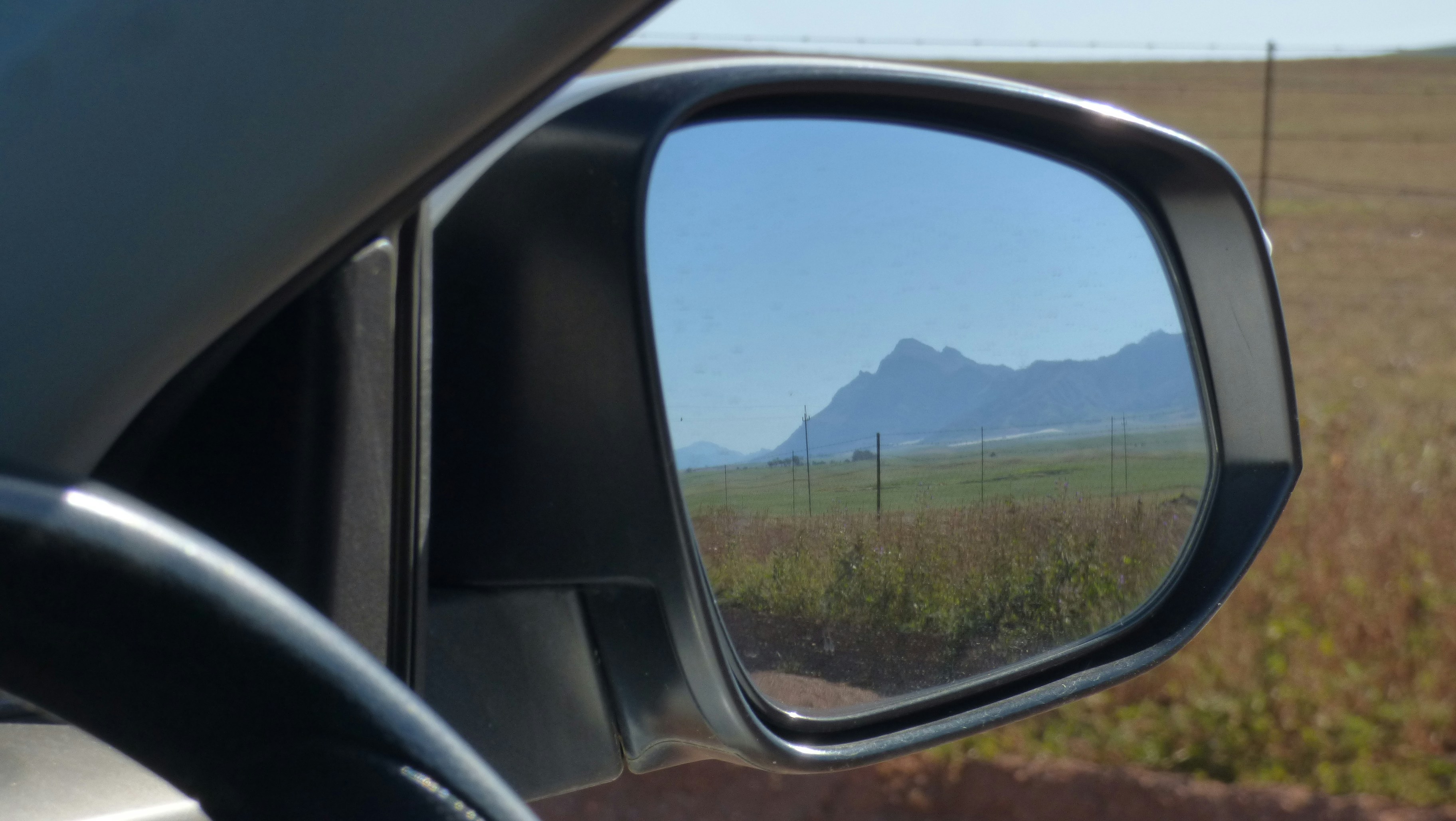 Horizon in the Passenger View: Mountains Framed in a Car’s Side Mirror