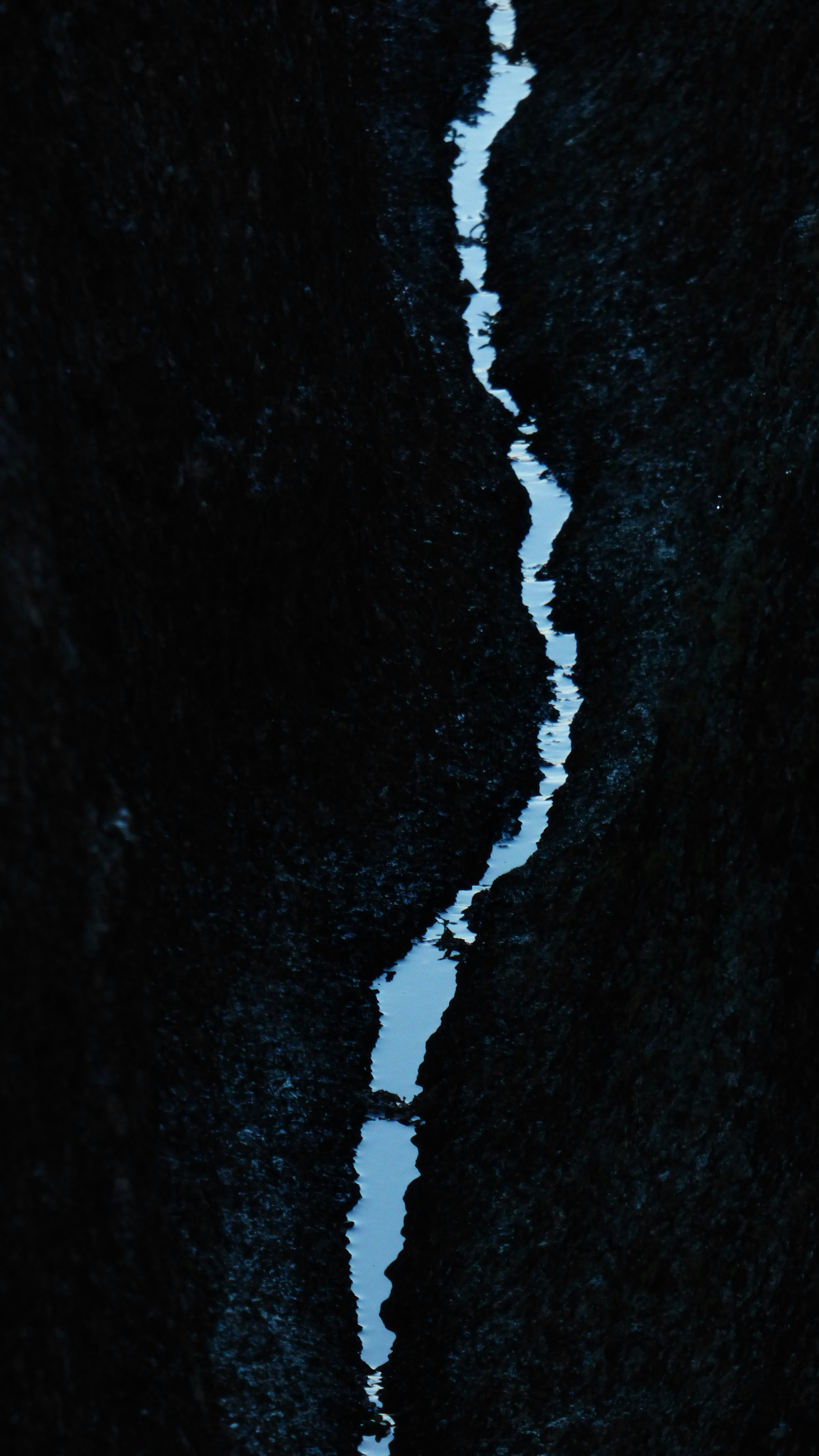 Crack of blue light: a canyon seam under shadow