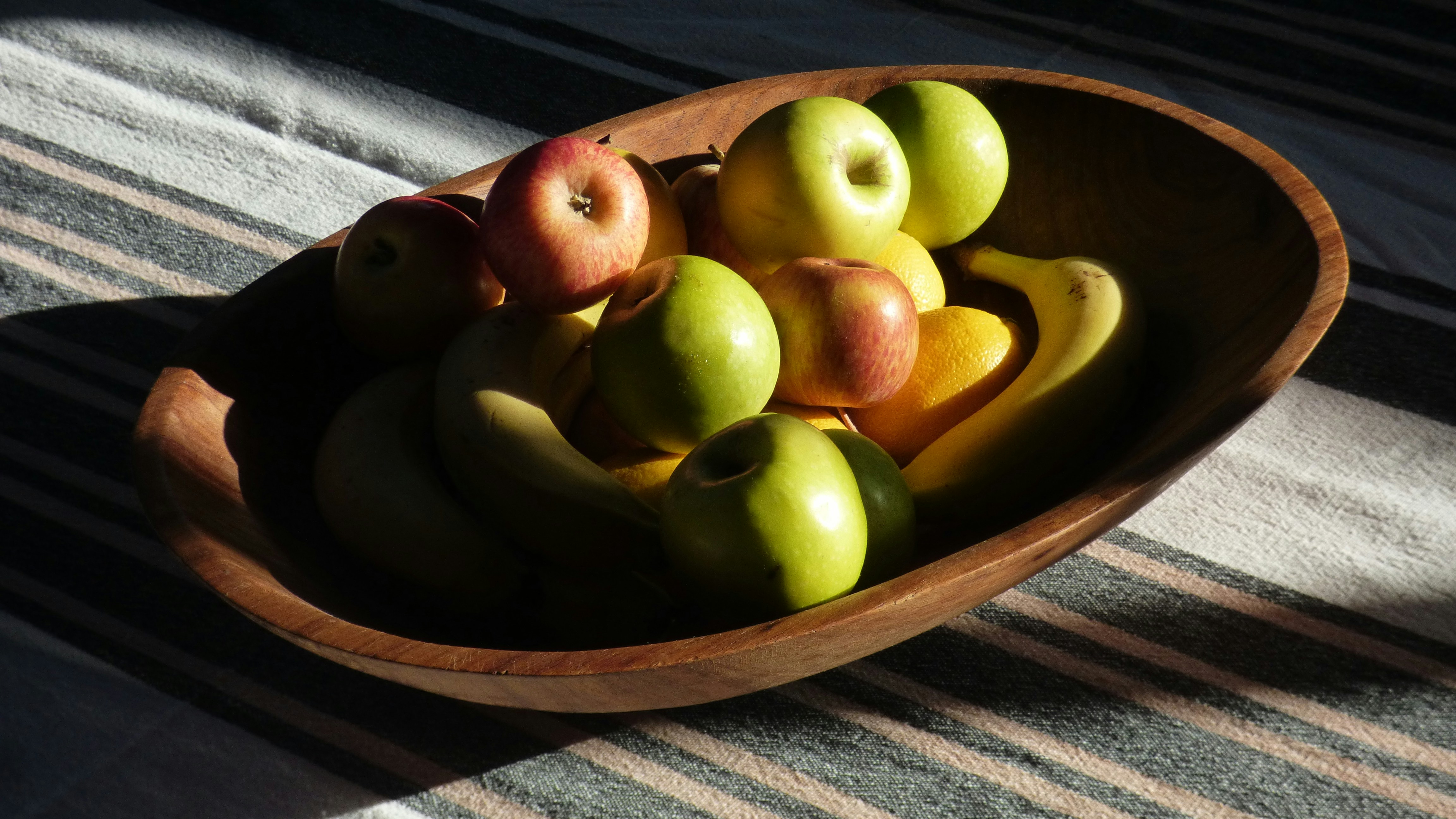 Sunlit Orchard Bowl: Apples and Mangoes in a Wooden Tray