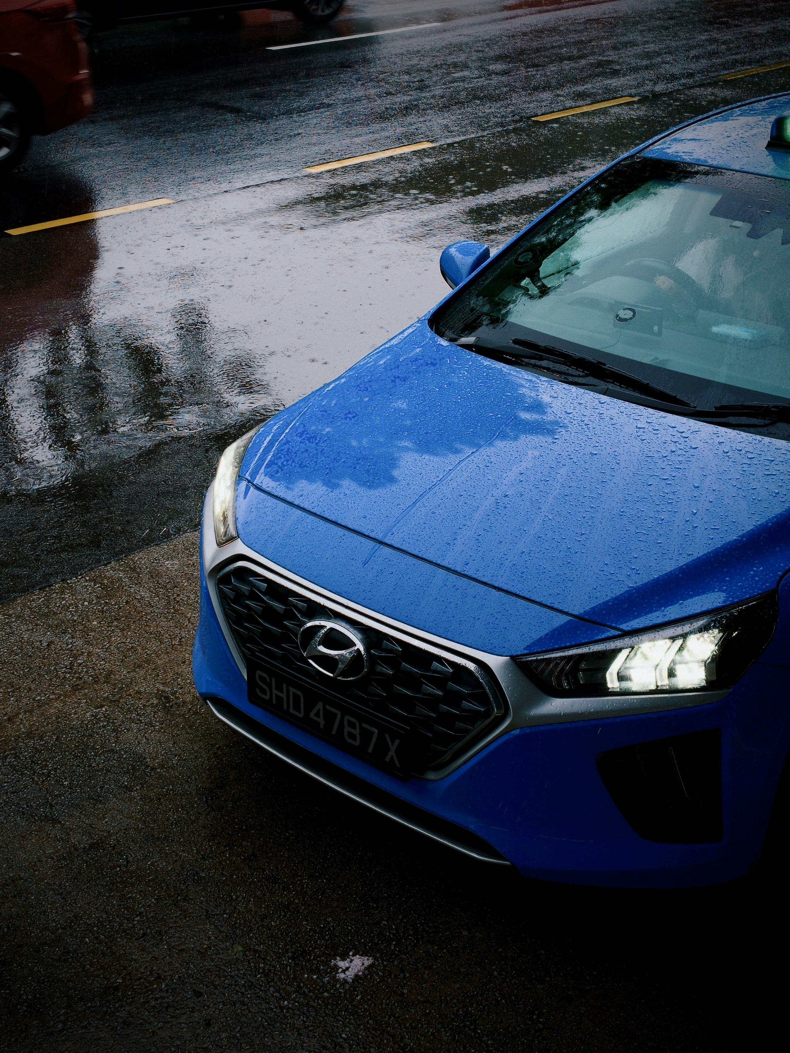 Blue Hyundai Streak as Rain Drops Blur the Street