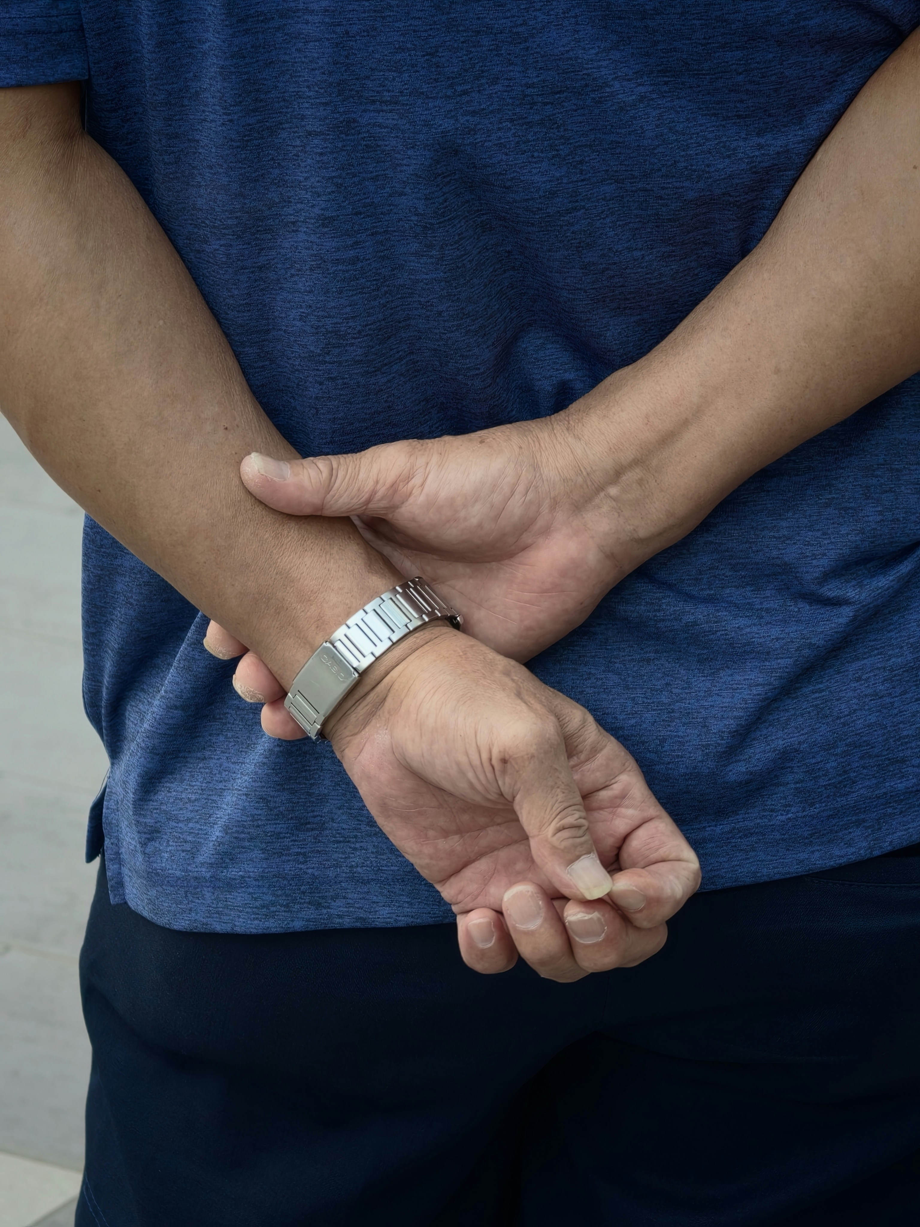 Interlocked Hands: Quiet Proximity Under Blue Fabric