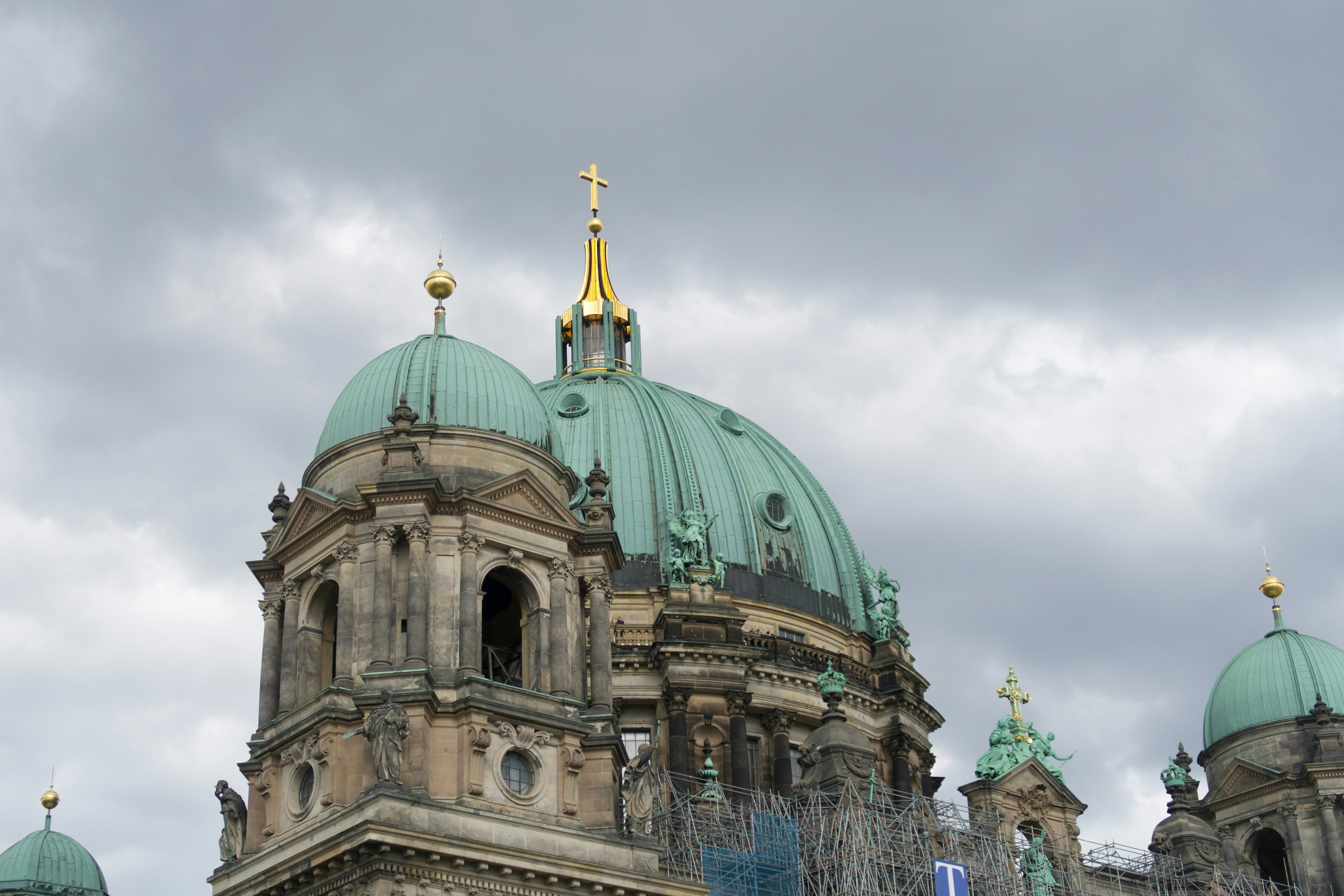 Dome and Cross: Cathedral Rooflines Reaching Toward a Cloudy Sky