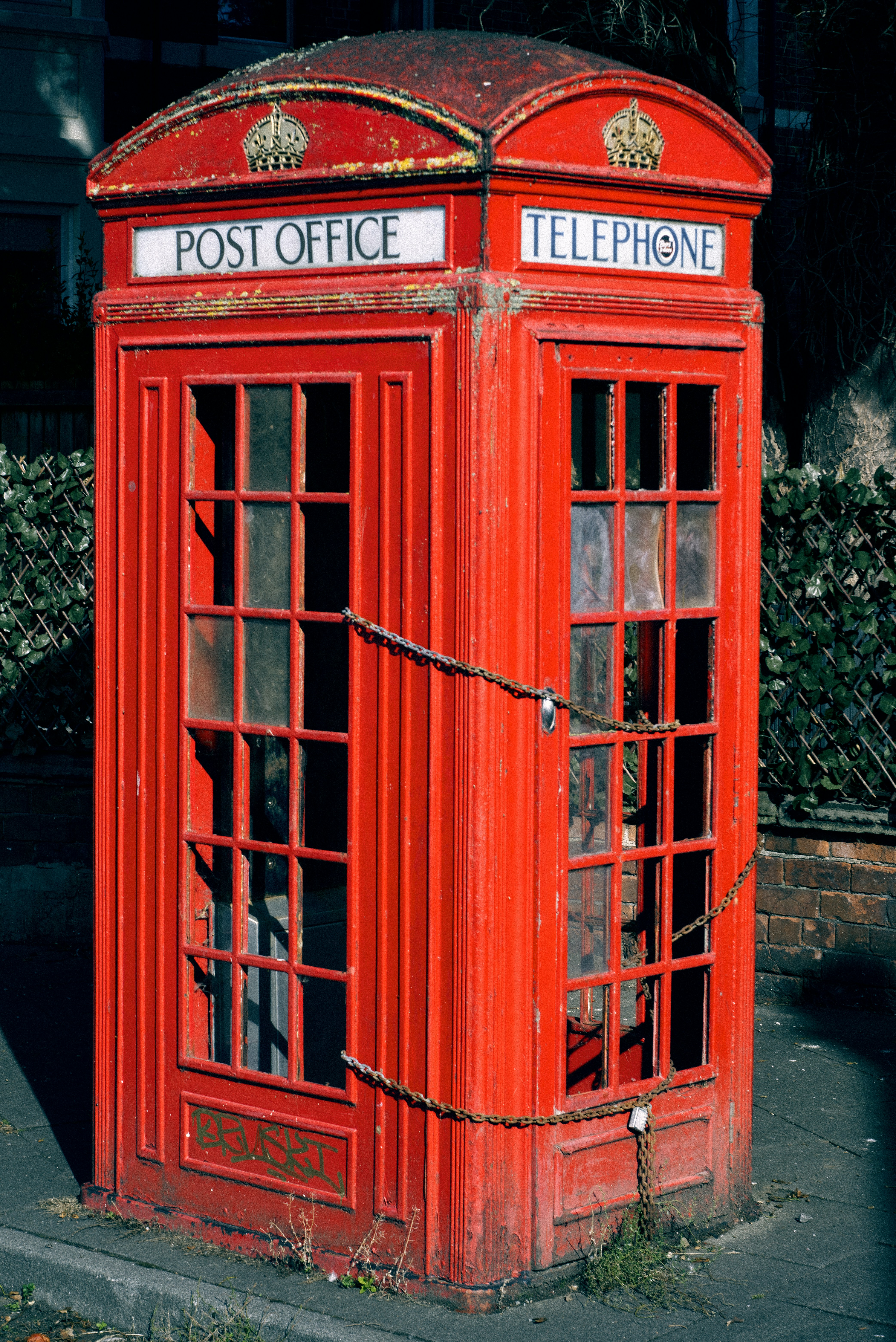 Crimson Red Guardian: A Classic British Telephone Kiosk in Morning Light