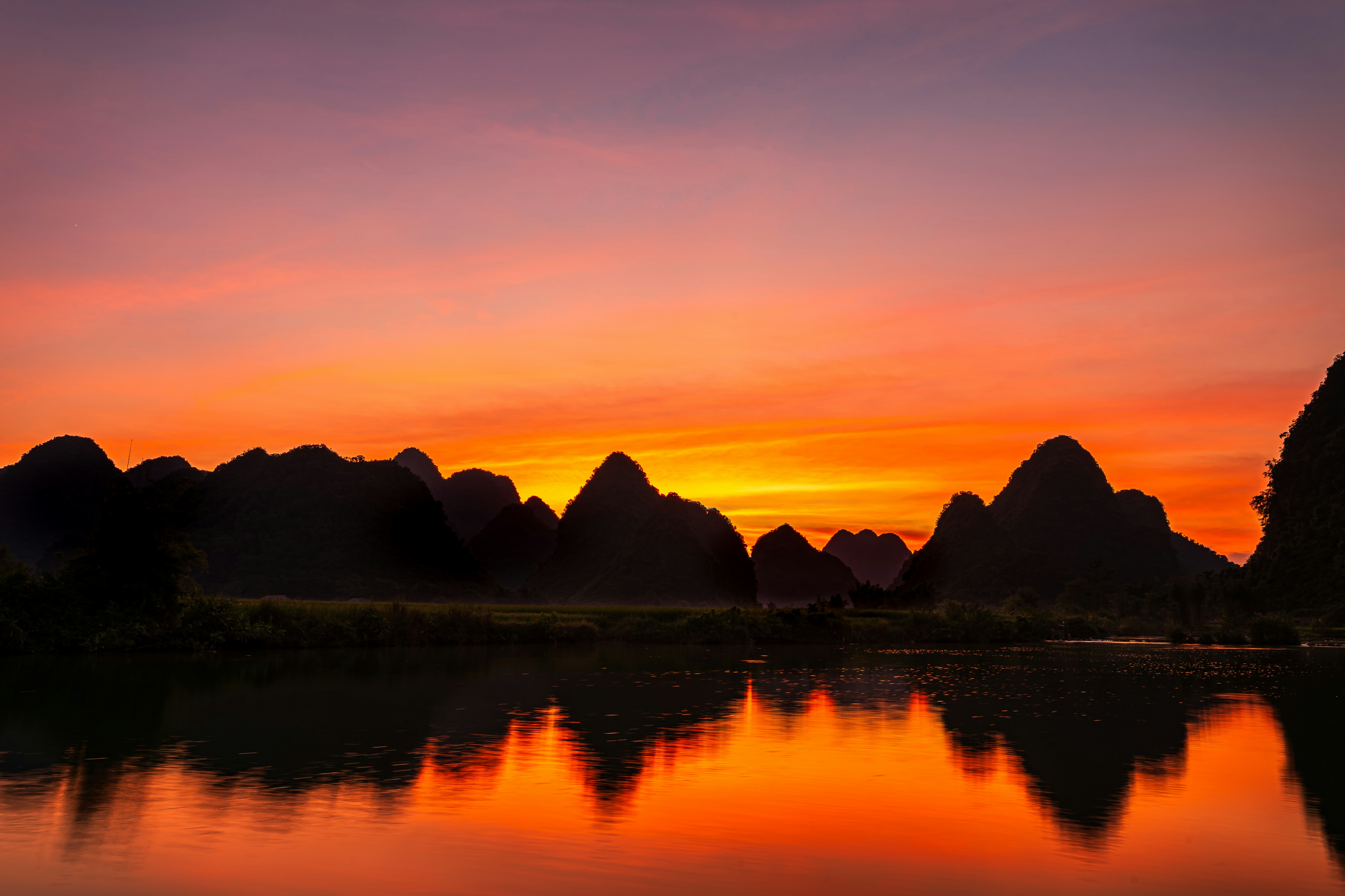Crimson Horizon Over Quiet Karst Silhouette