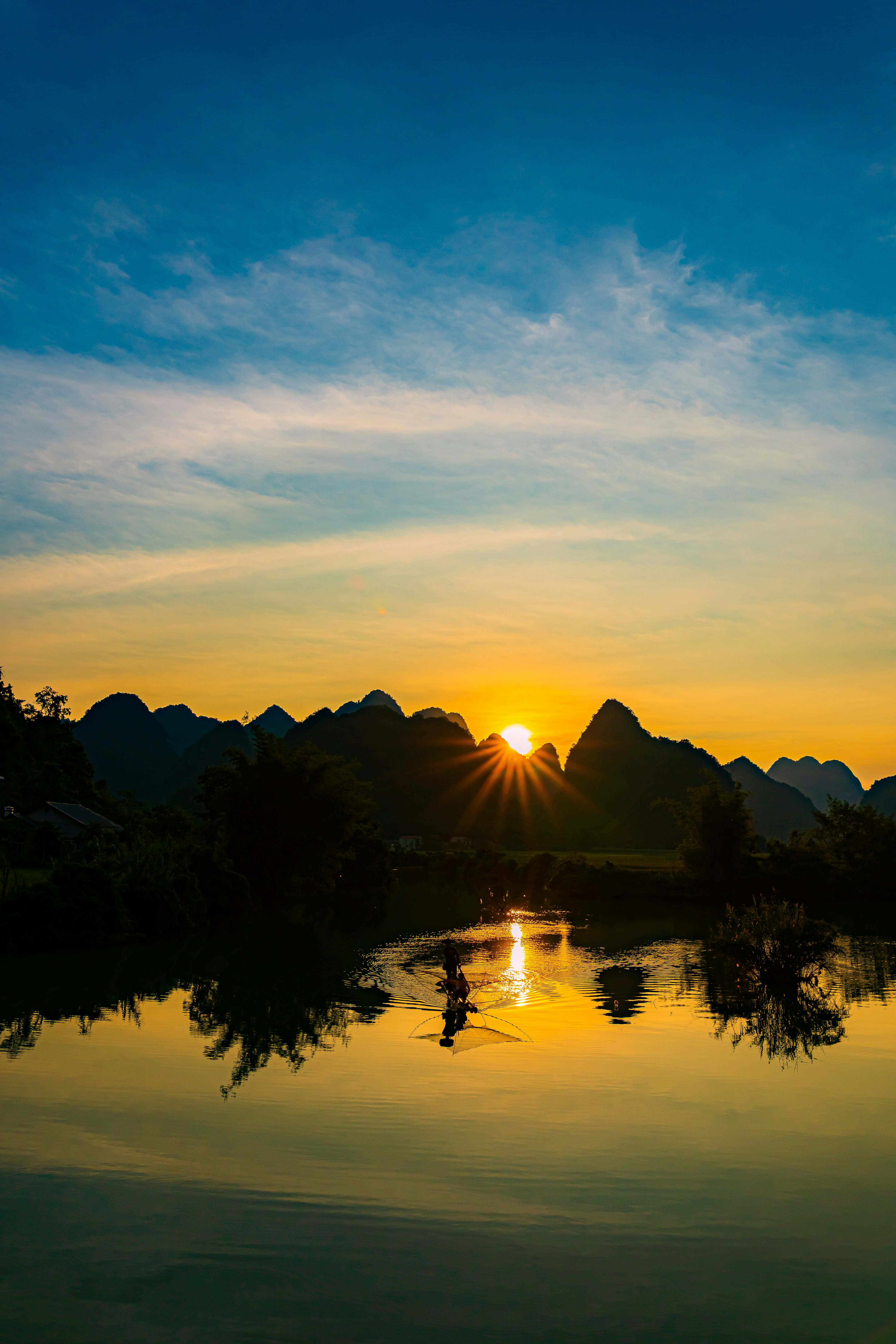 Sunburst Over Silhouetted Peaks at Dusk